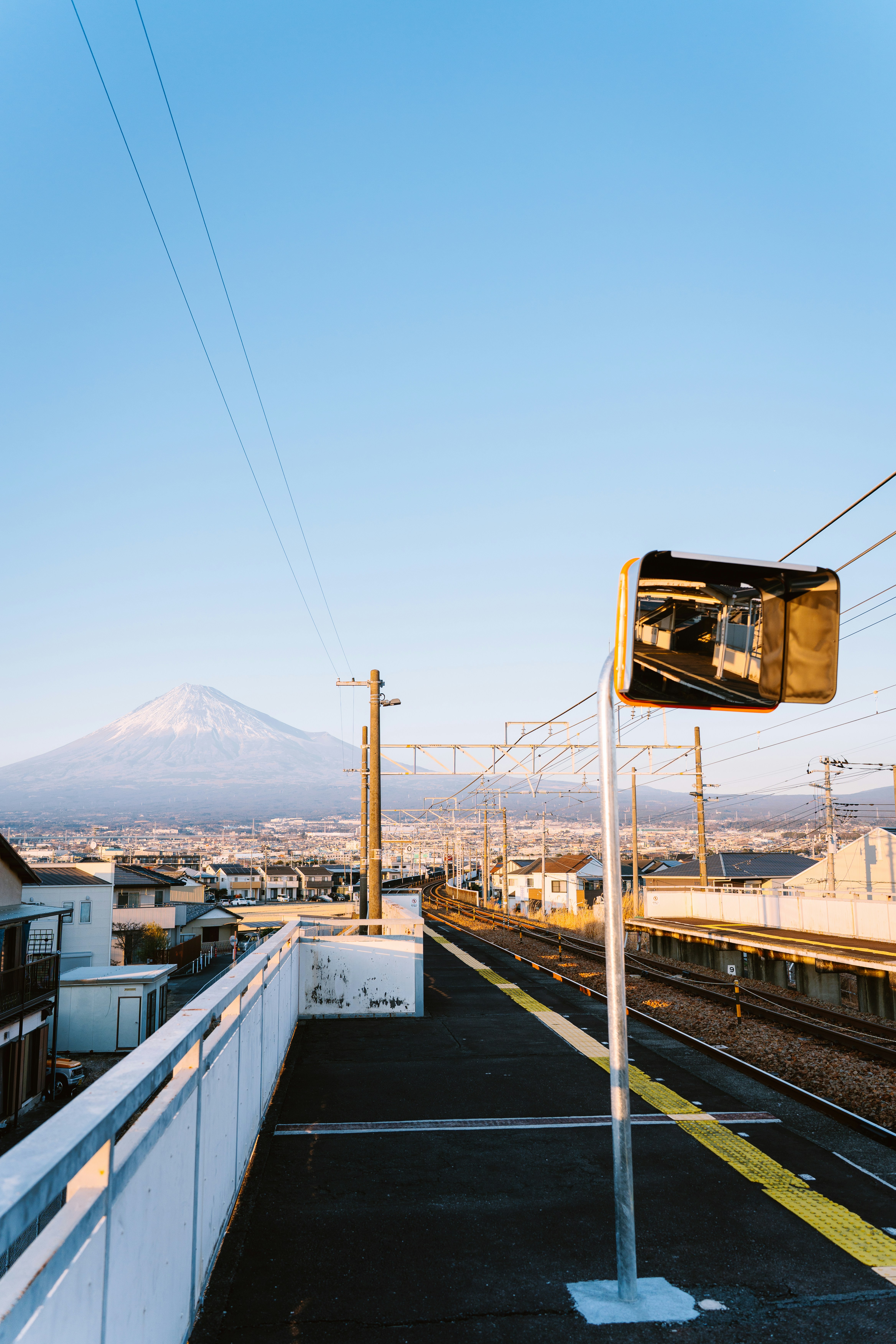 A train station with mount fuji in the background.