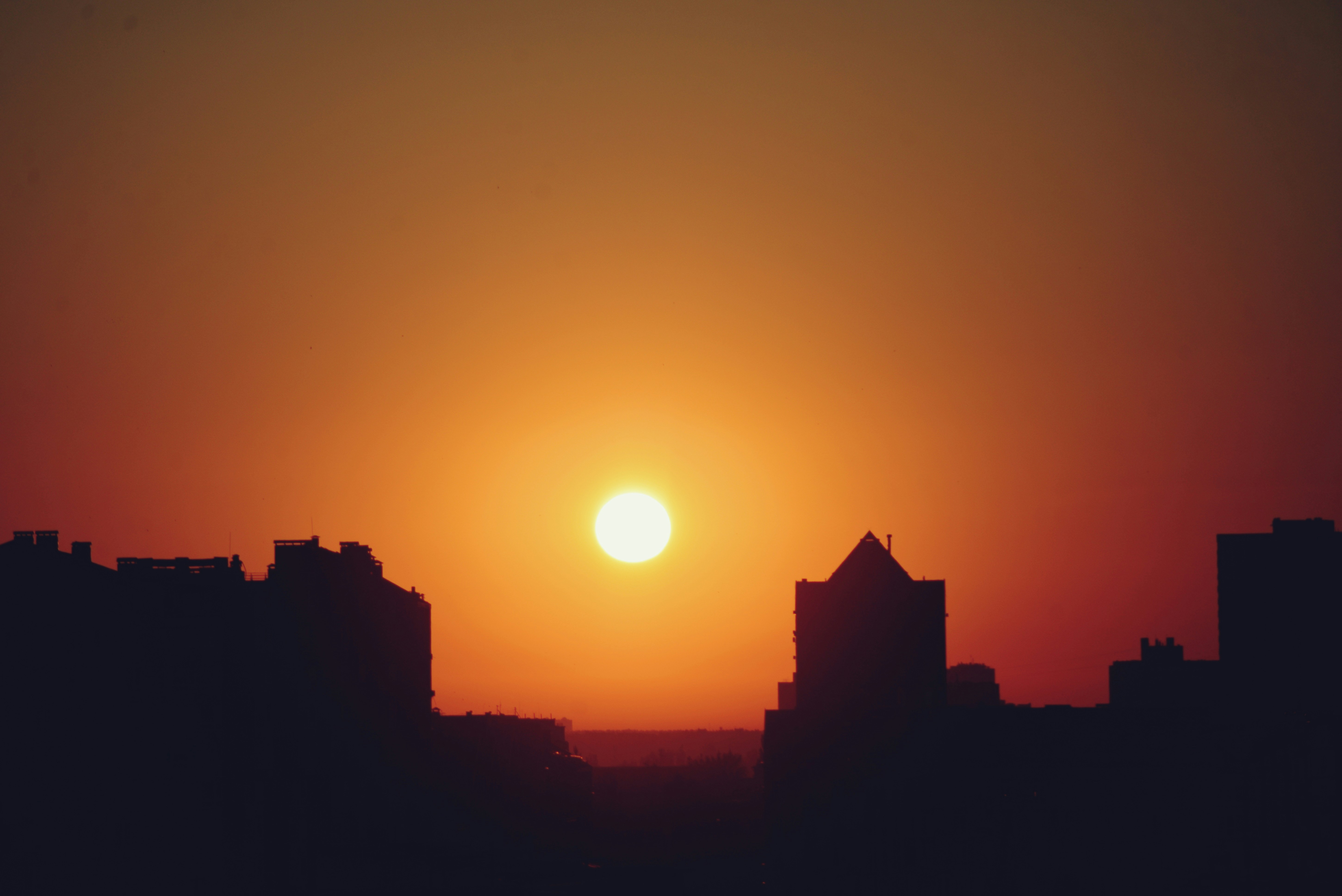 A sunset illuminates the city's silhouette.