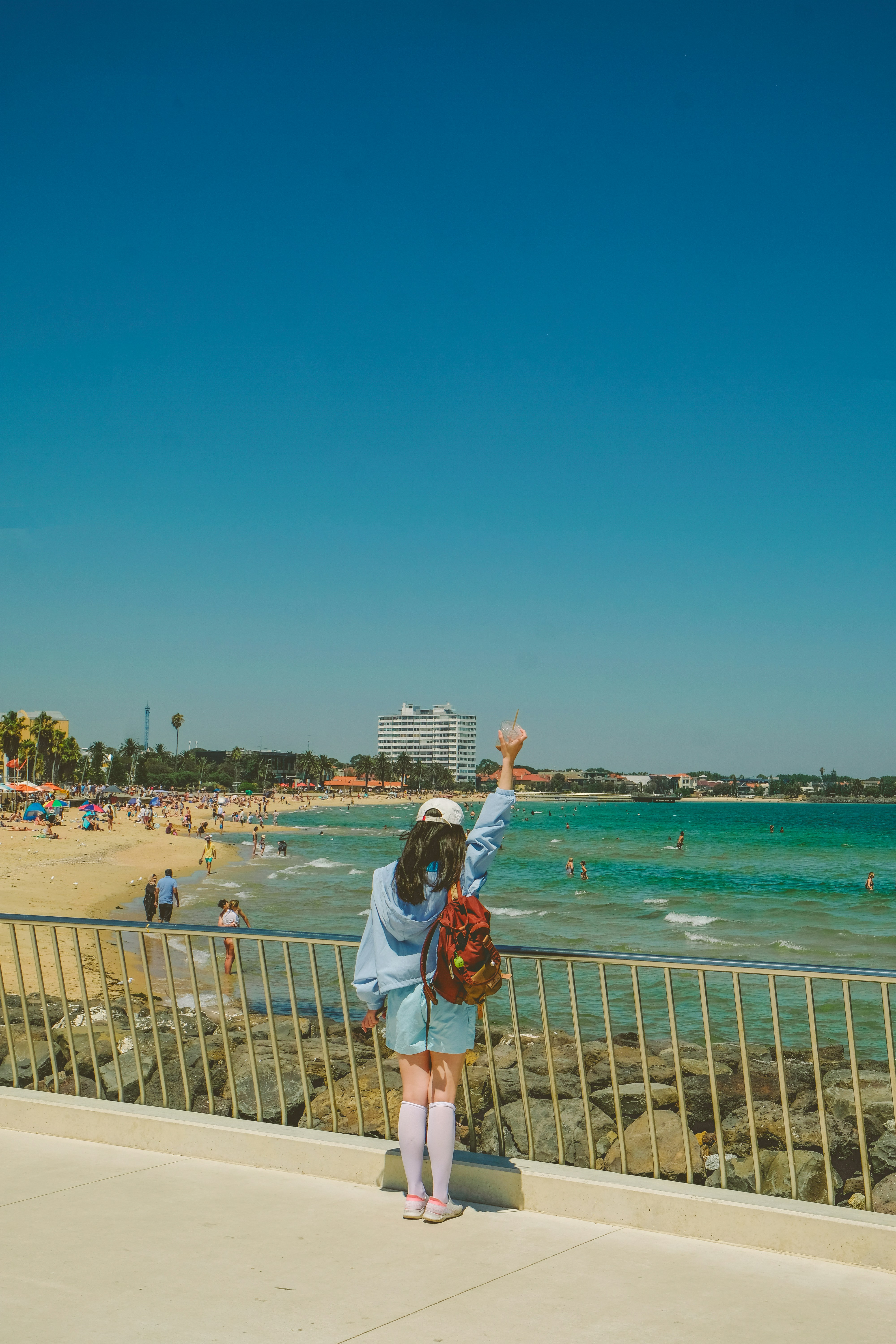 ready for summer | A woman stands at a beach, looking outward.