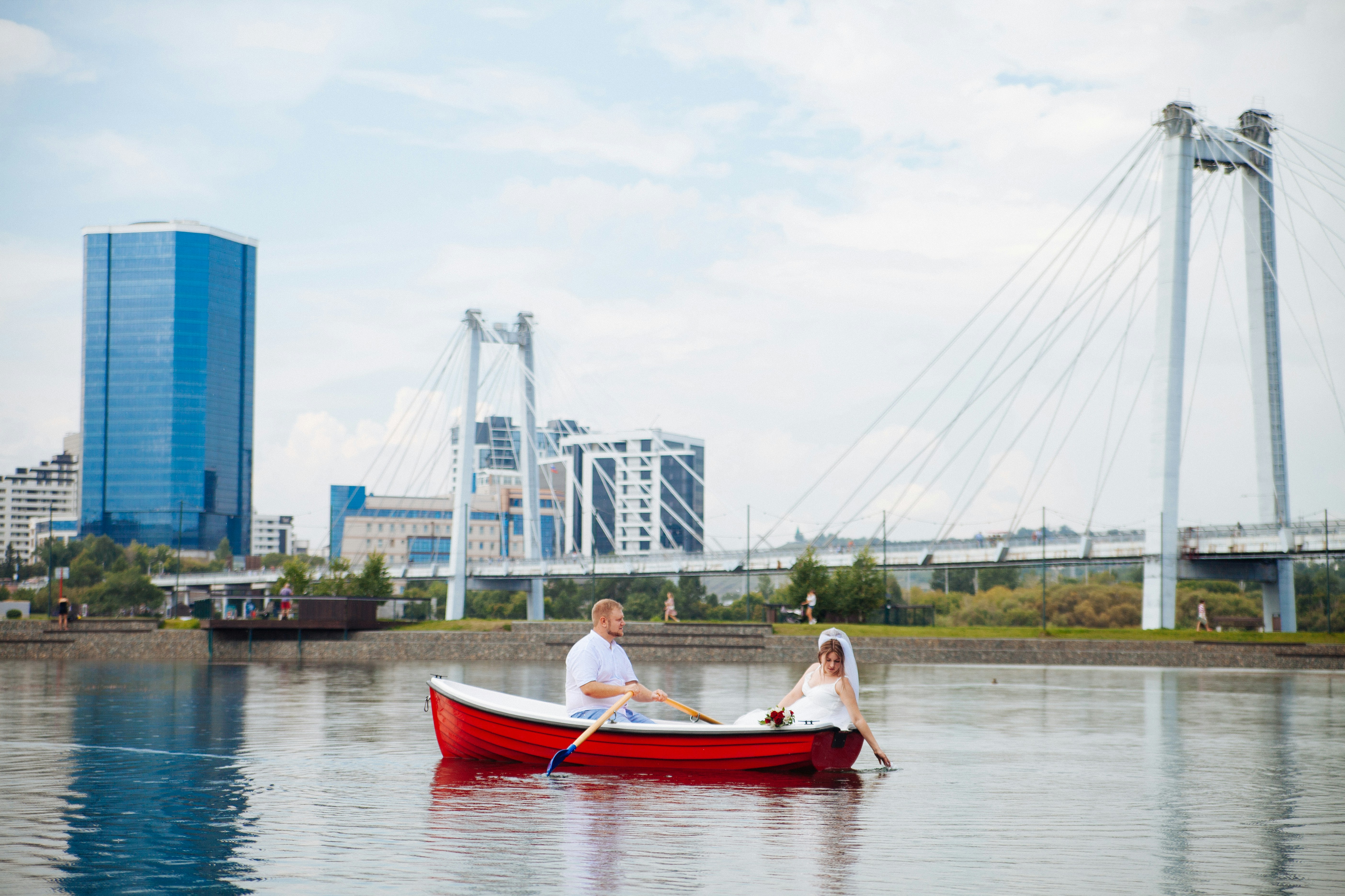 Newlyweds enjoy a romantic boat ride on the water.
