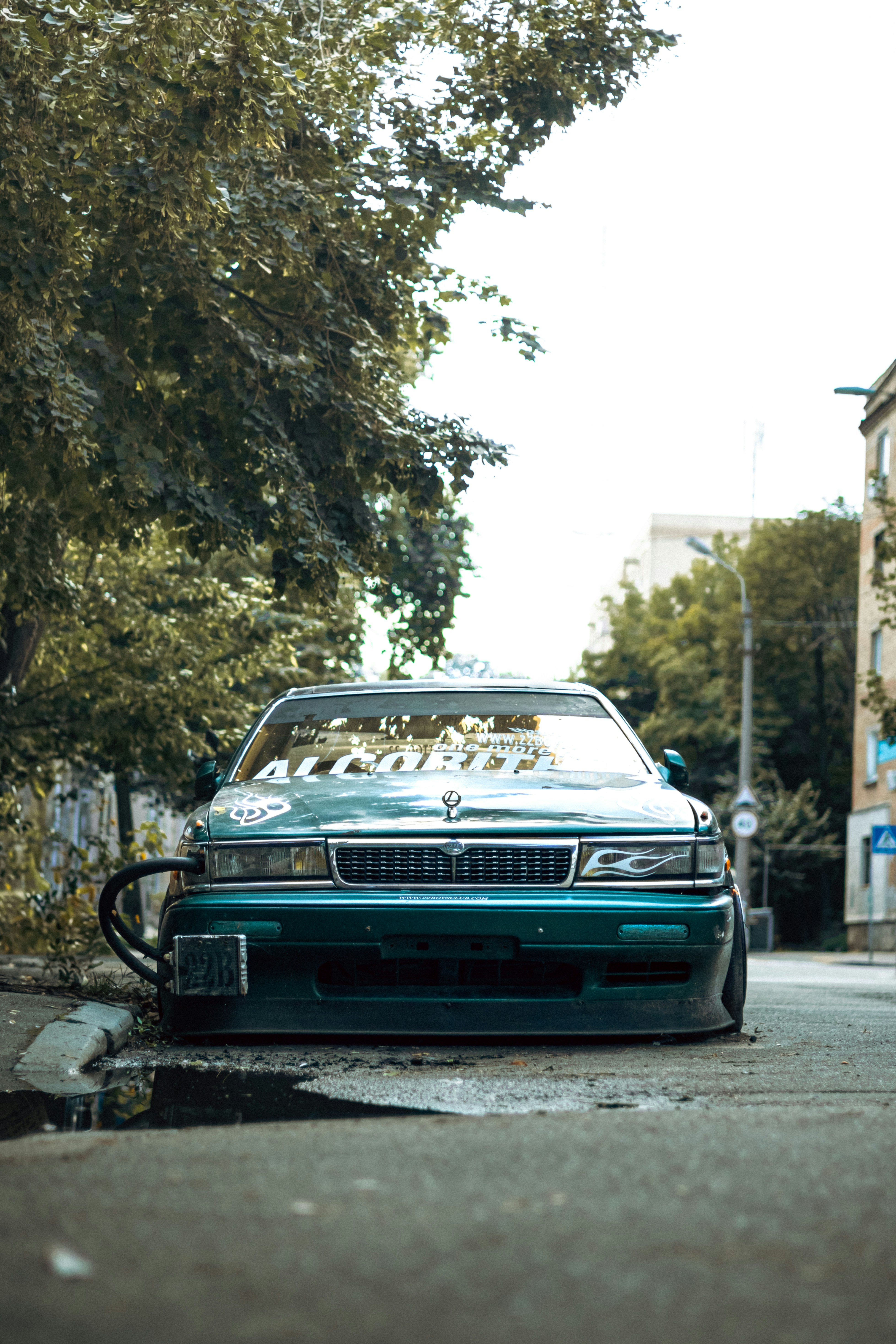A low-rider car is parked on the road.
