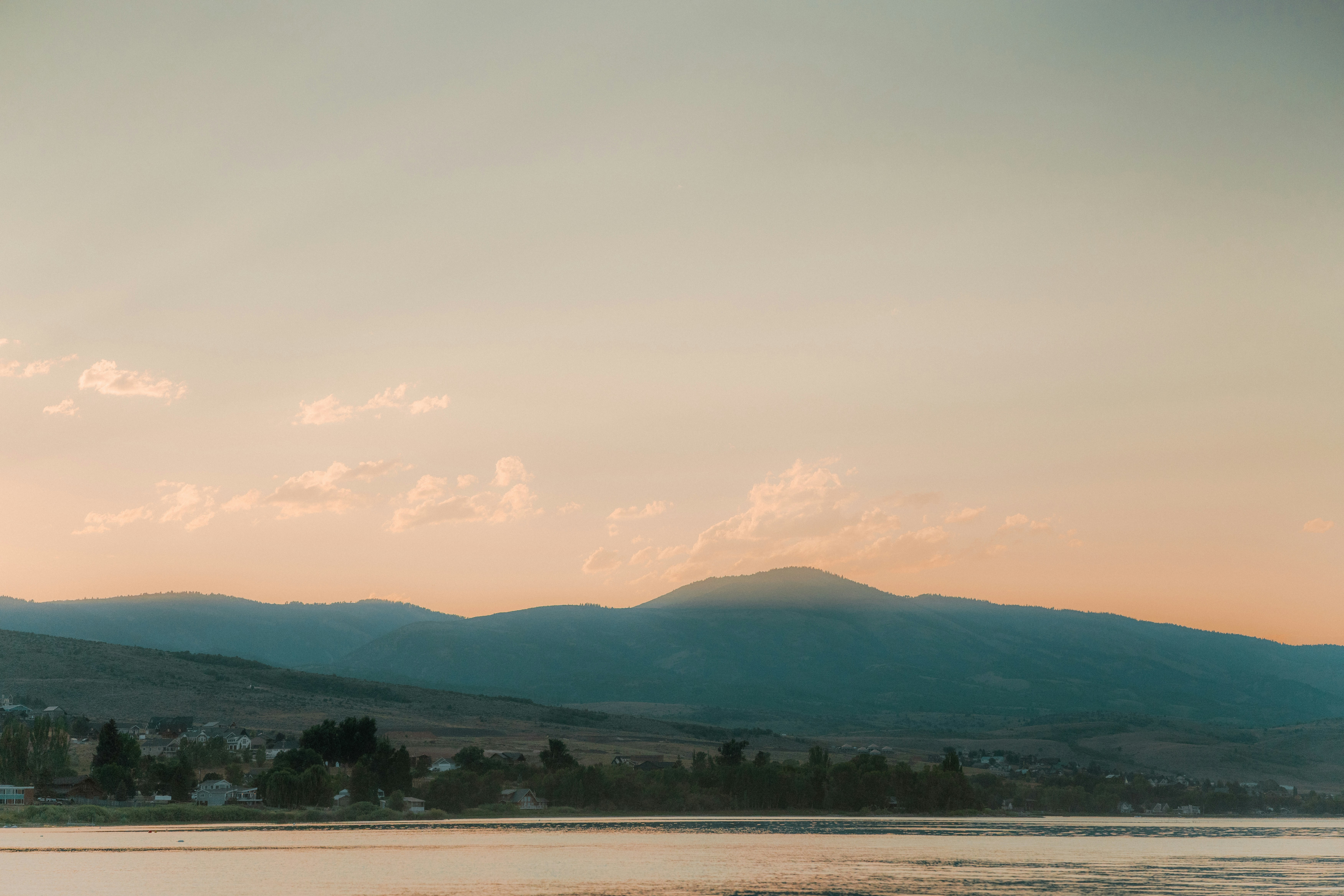 Mountains loom over a calm lake at dusk.