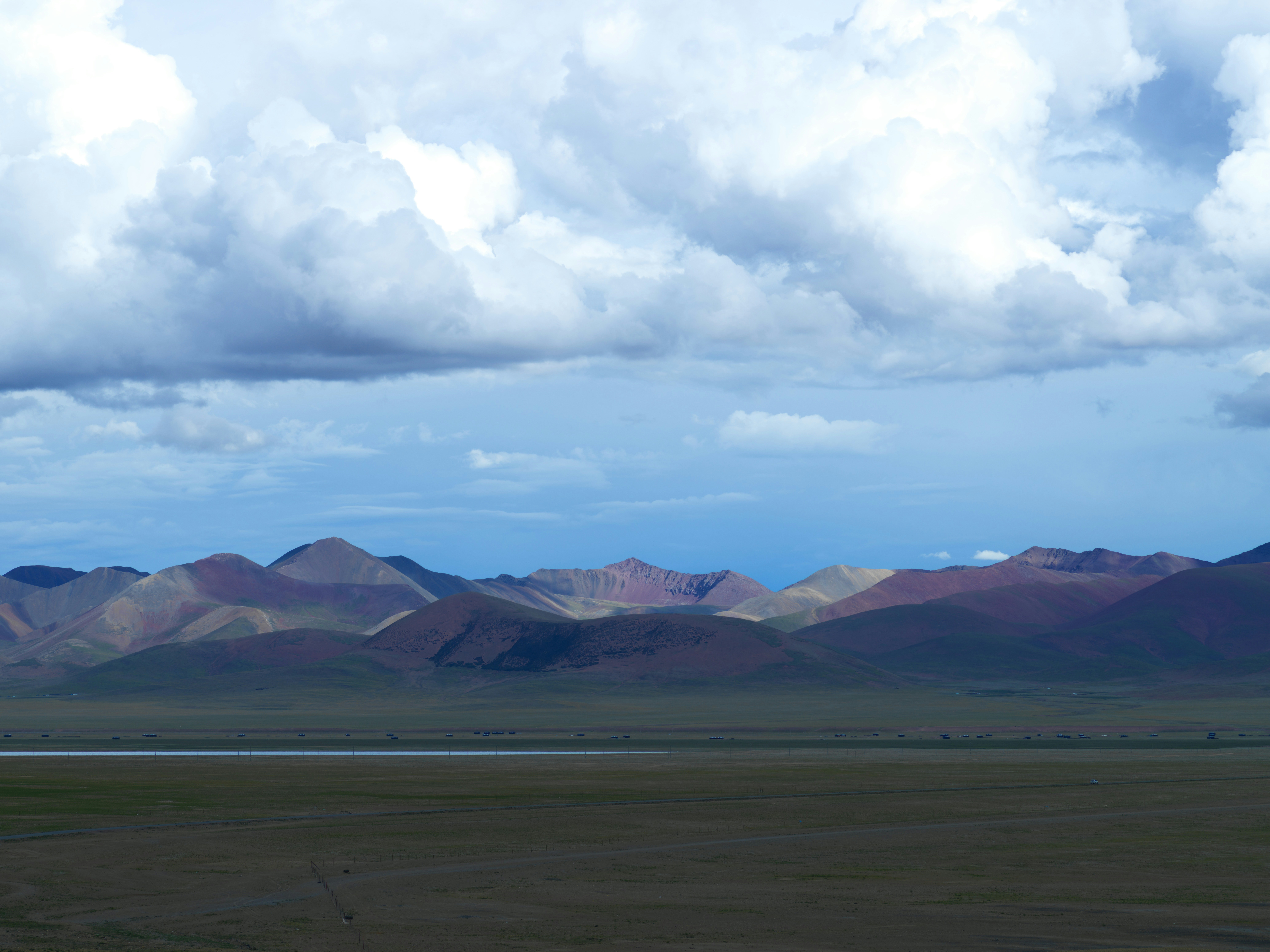 Mountains are beneath a cloudy sky.