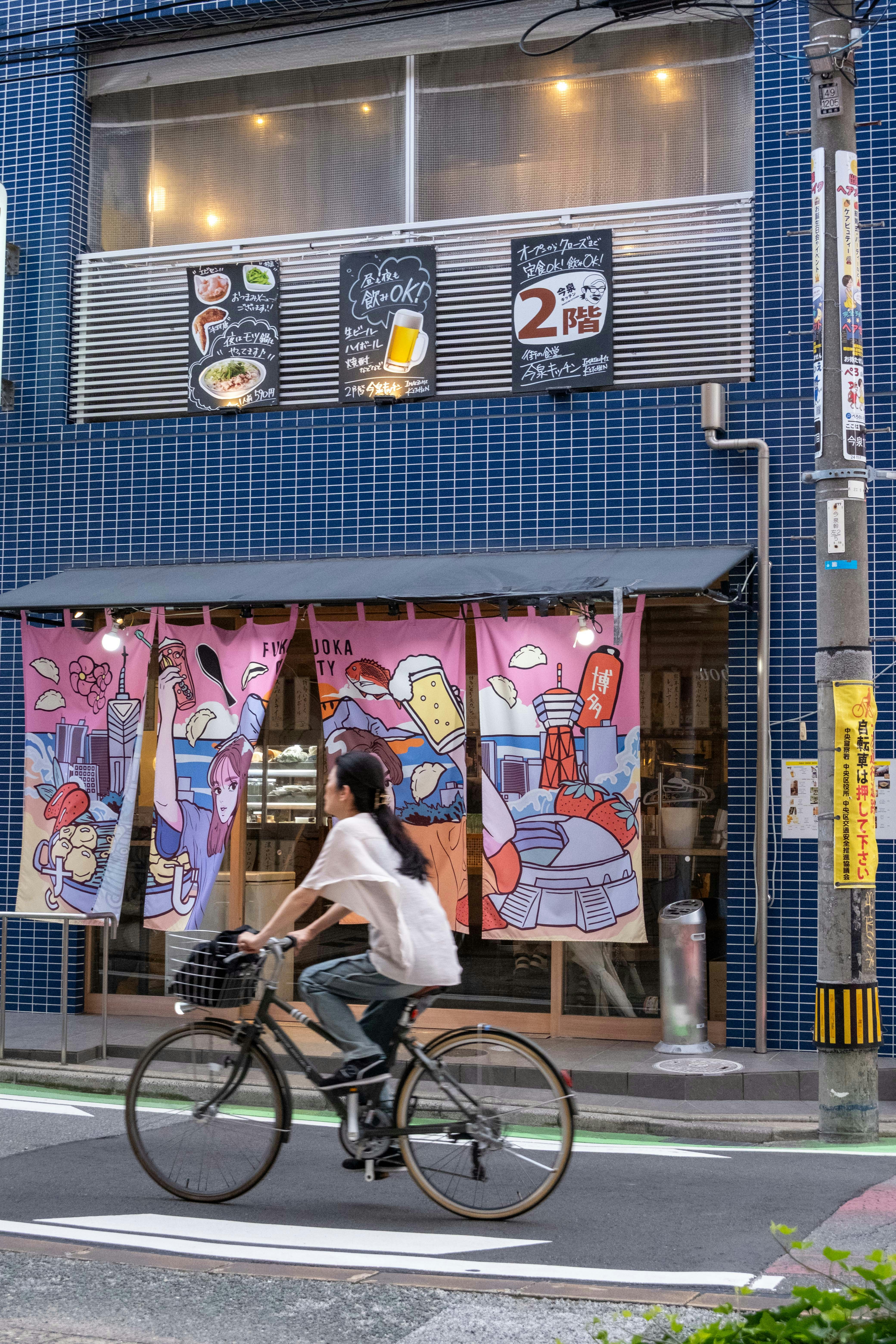 A cyclist passes by an asian restaurant.
