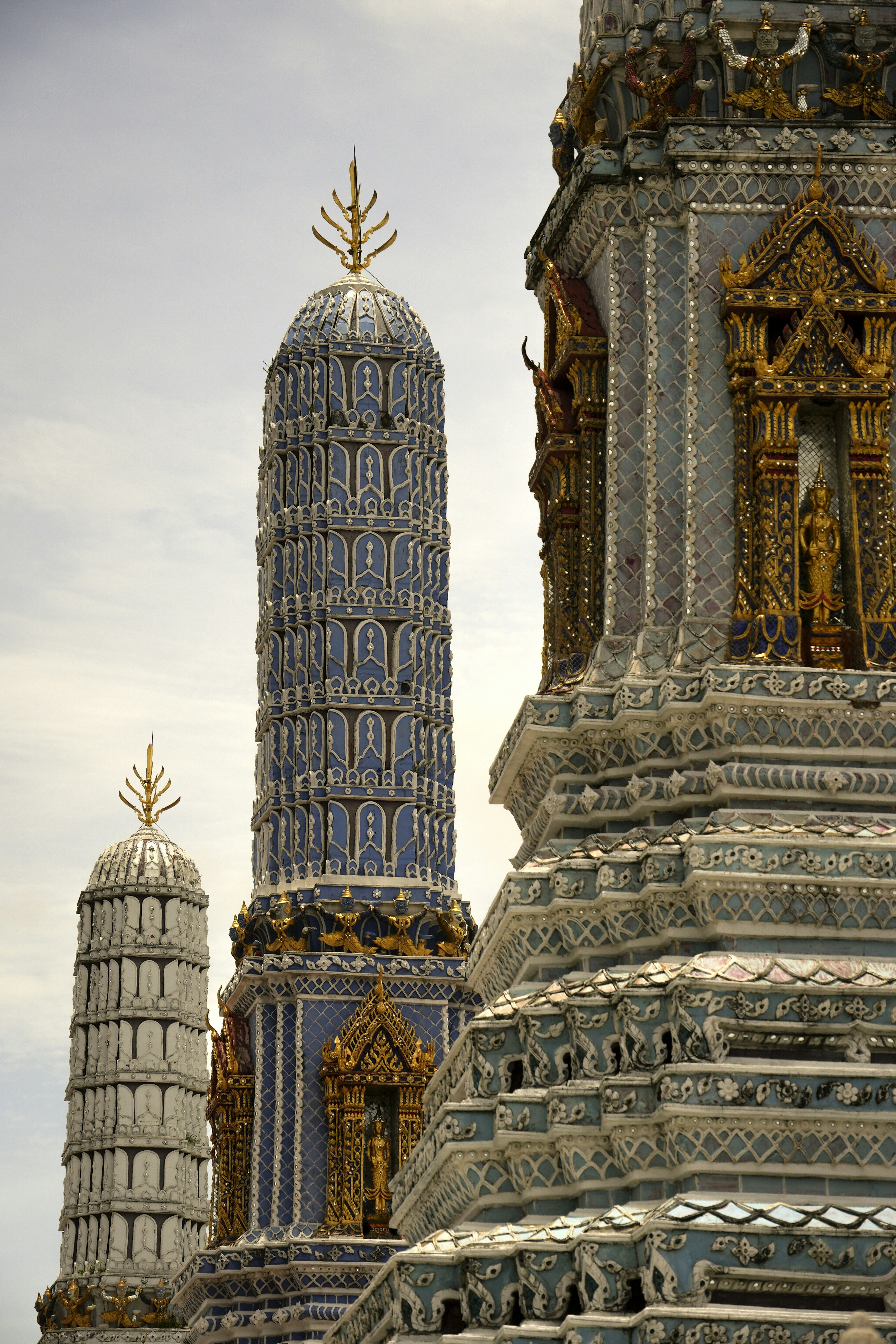Ornate thai temples stand tall in the bright sky.