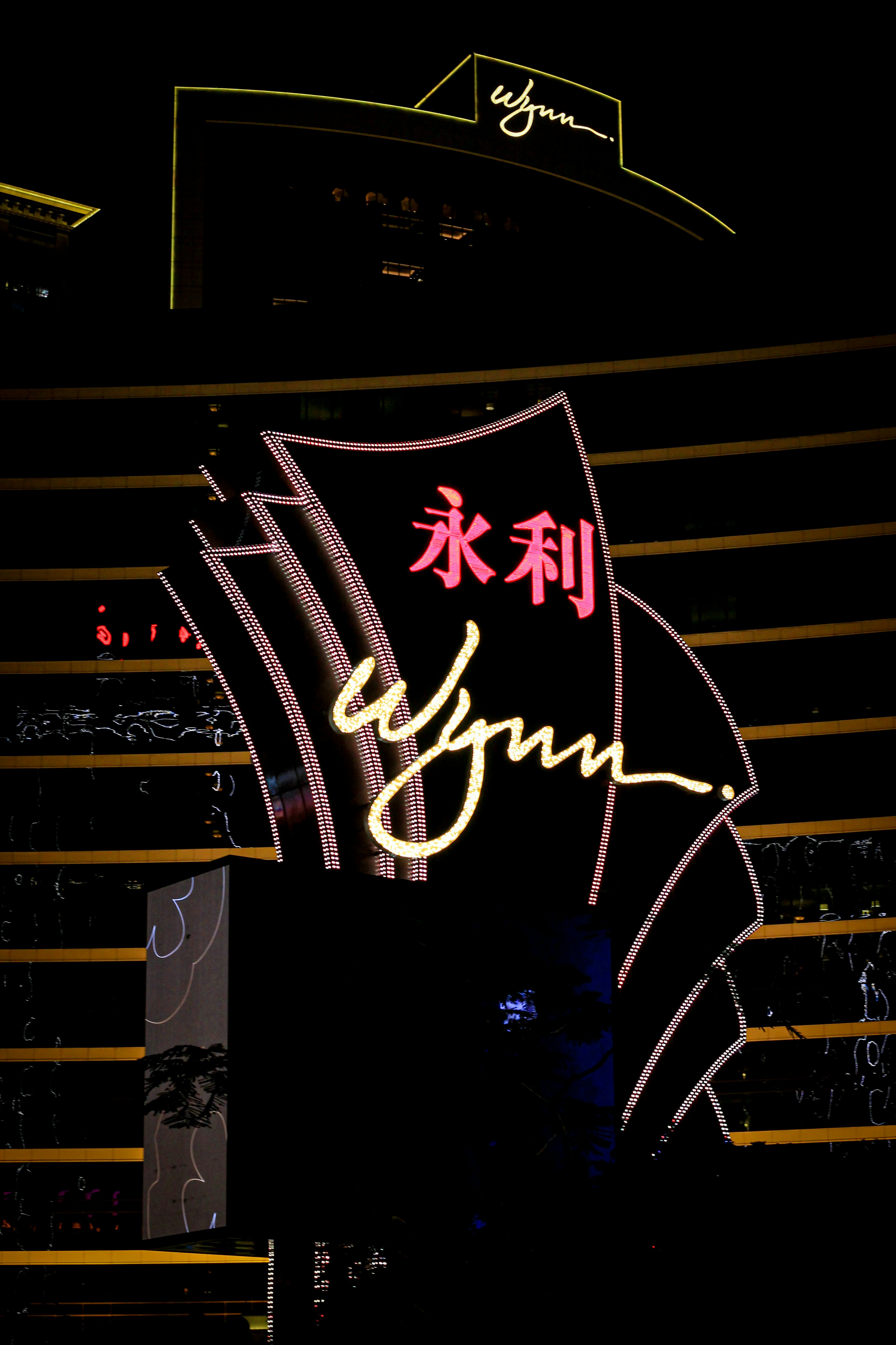 The wynn resort sign glows brightly in the dark.