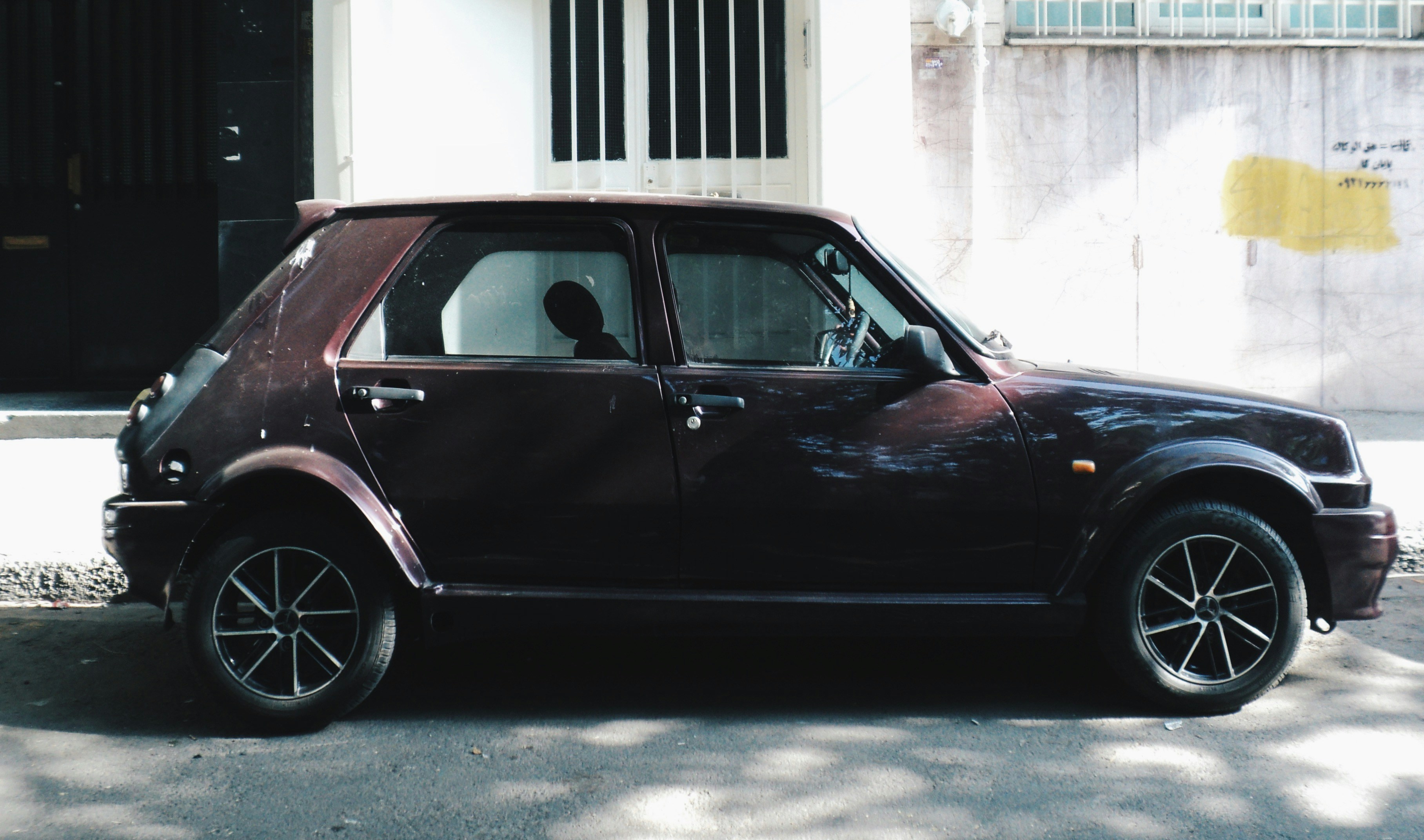 An old soul with a new attitude. | A dark red car is parked on the street.