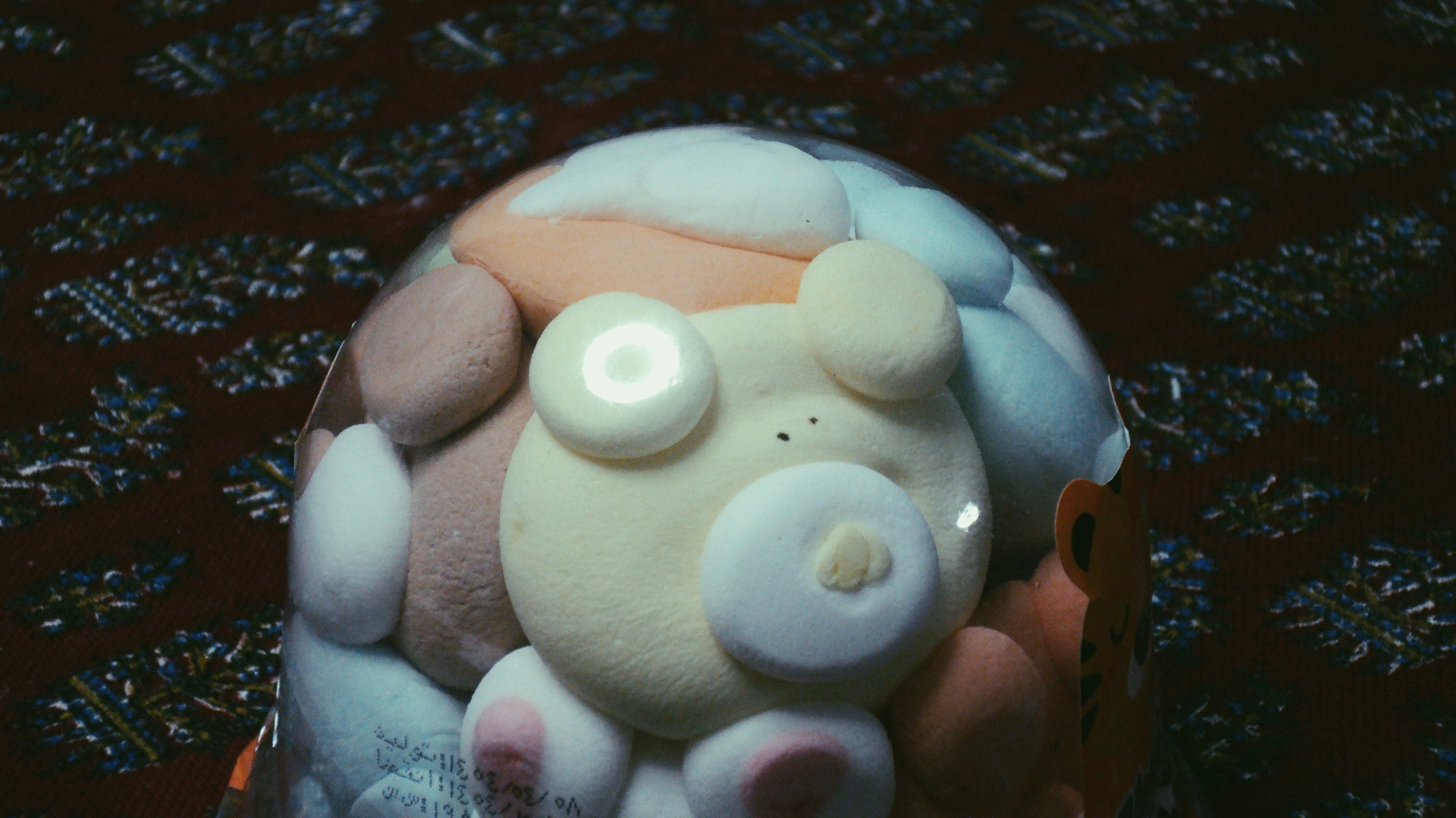 Too cute to eat. | A marshmallow teddy bear inside a glass dome.