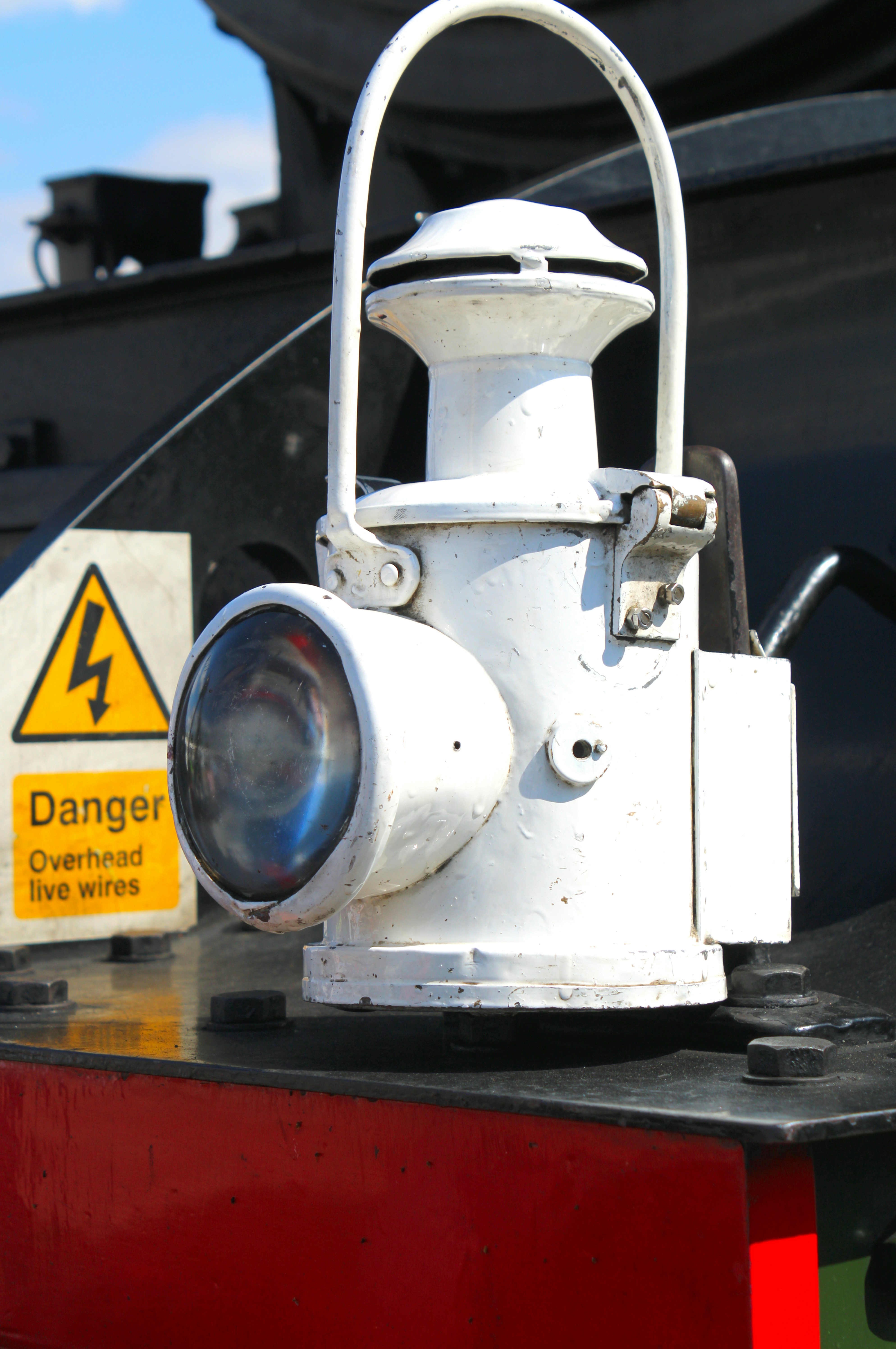 An old, white train lamp is shown.