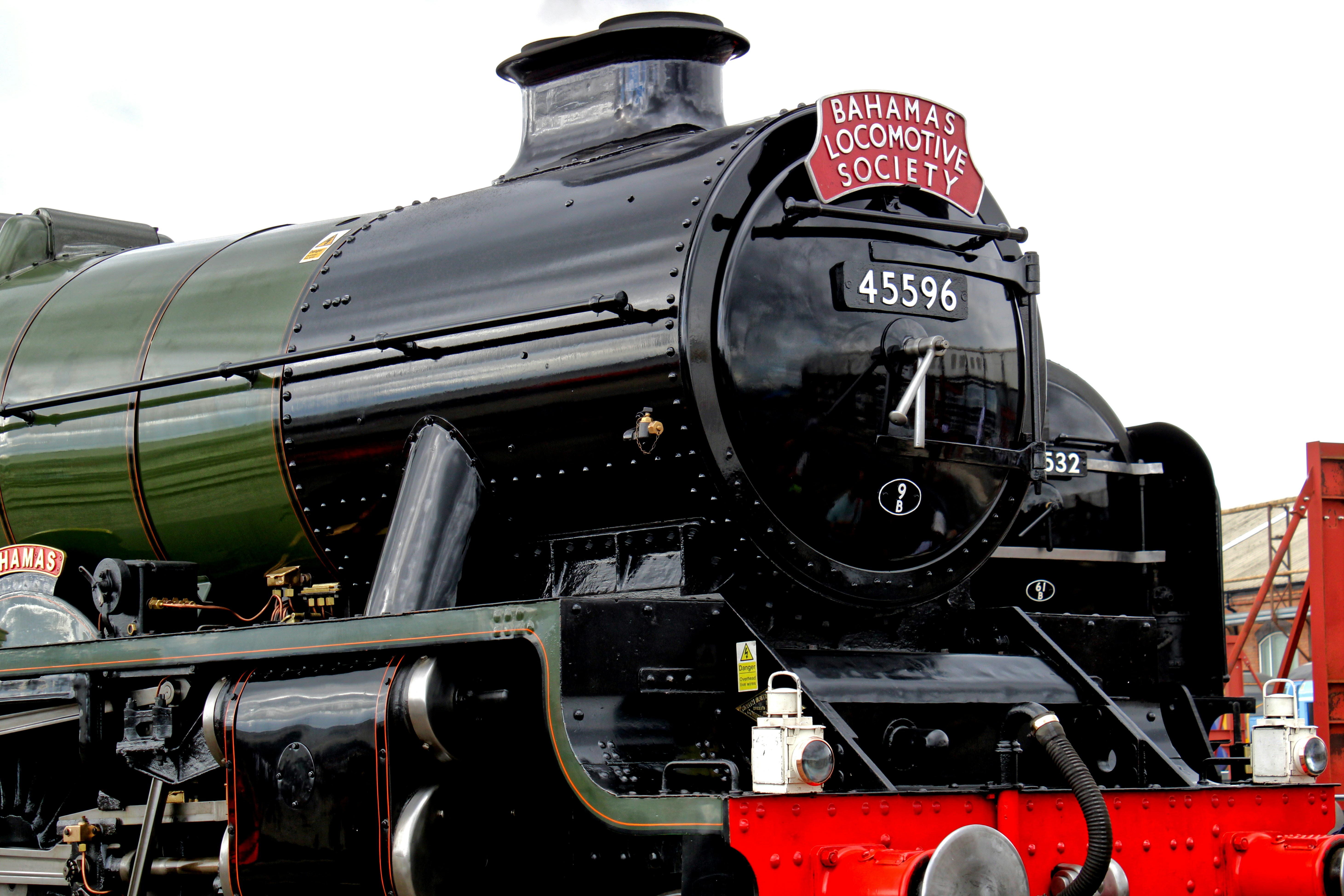 Close-up of a vintage steam locomotive showcasing intricate details and the iconic 'Bahamas Locomotive Society' sign.
