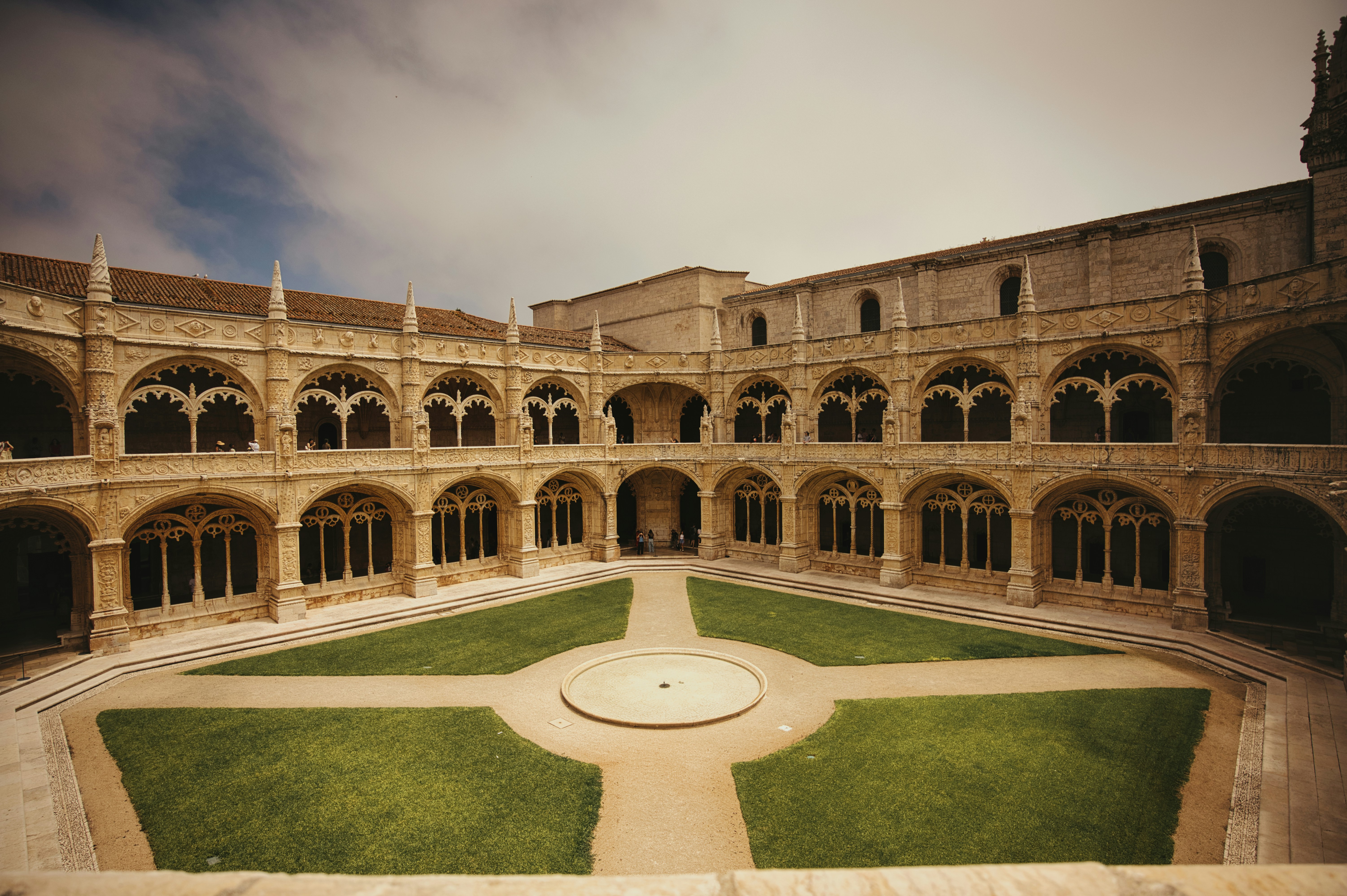 Symmetry in Stone: Sunlit Cloister Courtyard with Circular Fountain