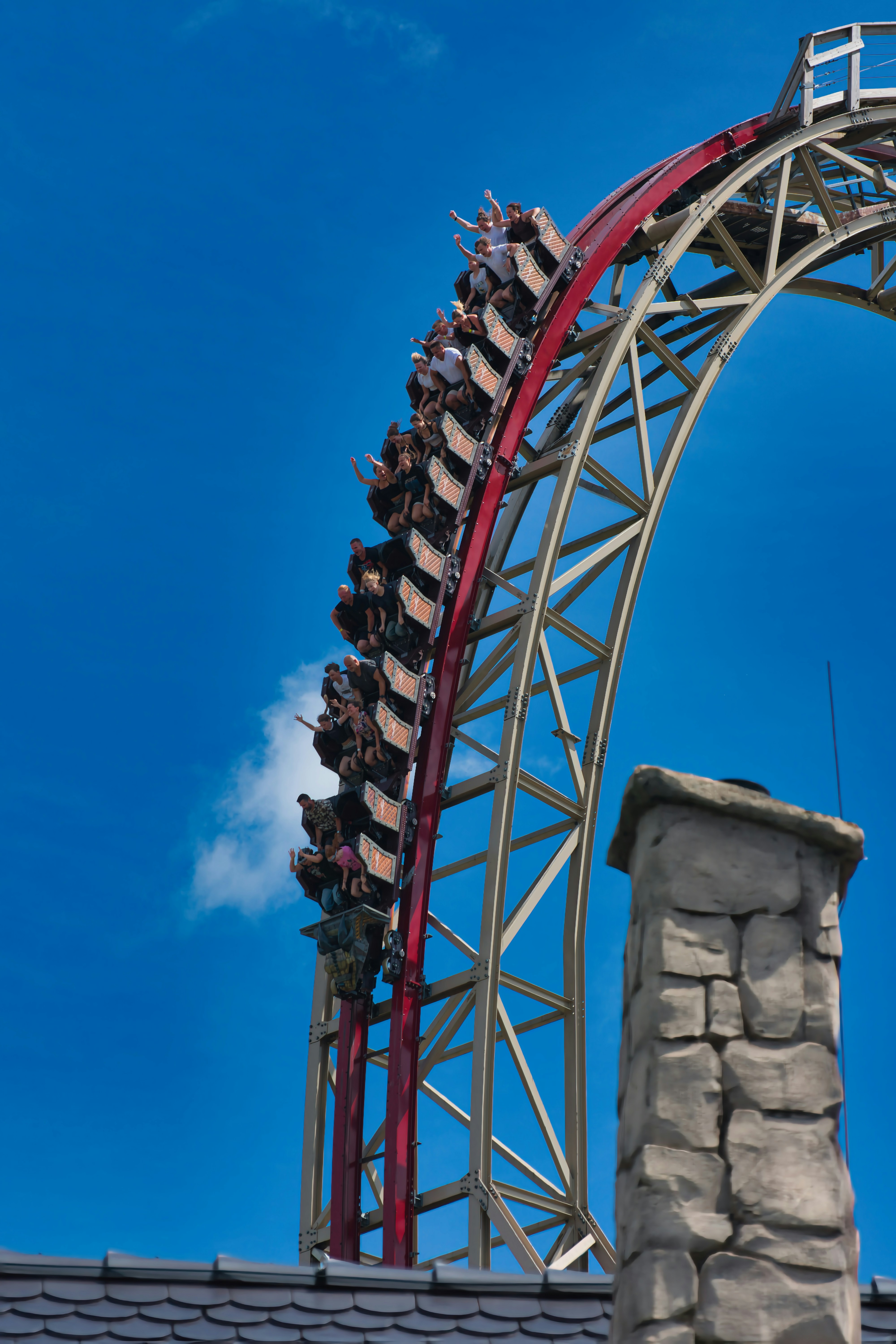 Zadra — the wooden steel monster of Energylandia. With a 90° drop from 62.8 m and a top speed of 121 km/h, Zadra is a masterclass in RMC intensity. Three inversions, relentless pacing, and fluid airtime hills make this hybrid coaster a standout thrill machine — raw, fast, and engineered for chaos. Type: Hybrid Coaster (RMC I-Box Track) Opened: 22 August 2019 Height: 62.8 m Length: 1,316 m Top Speed: 121 km/h Inversions: 3 (Zero-G Stall, Double Zero-G Roll) Drop Angle: 90° Duration: ~1:50 min G-Force: up to 4 g Trains: 2 trains with 6 cars (2 rows × 2 riders) Manufacturer: Rocky Mountain Const | Roller coaster climbs a tall, looping structure.