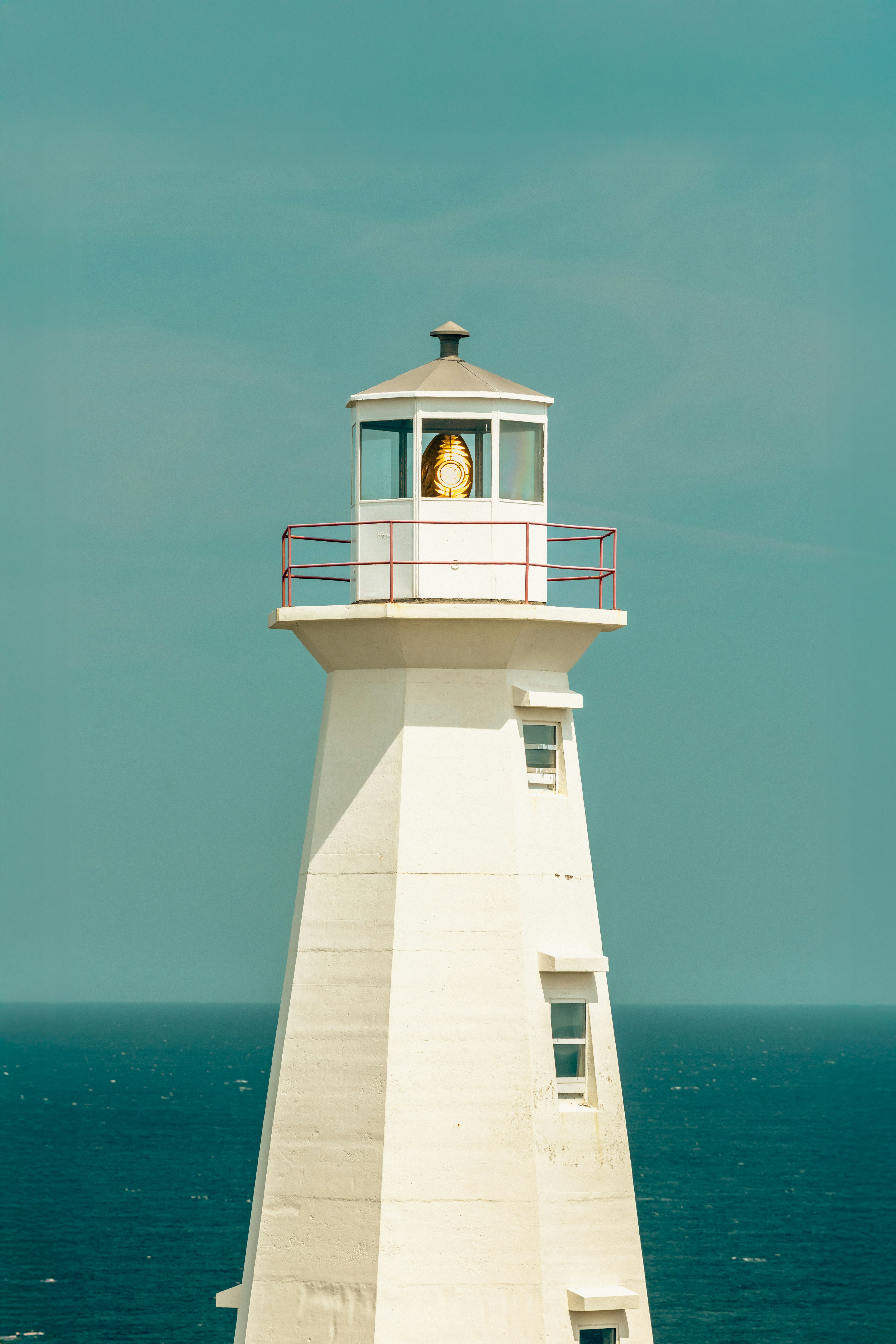 Guardian of the Atlantic | A white lighthouse stands tall against the ocean.