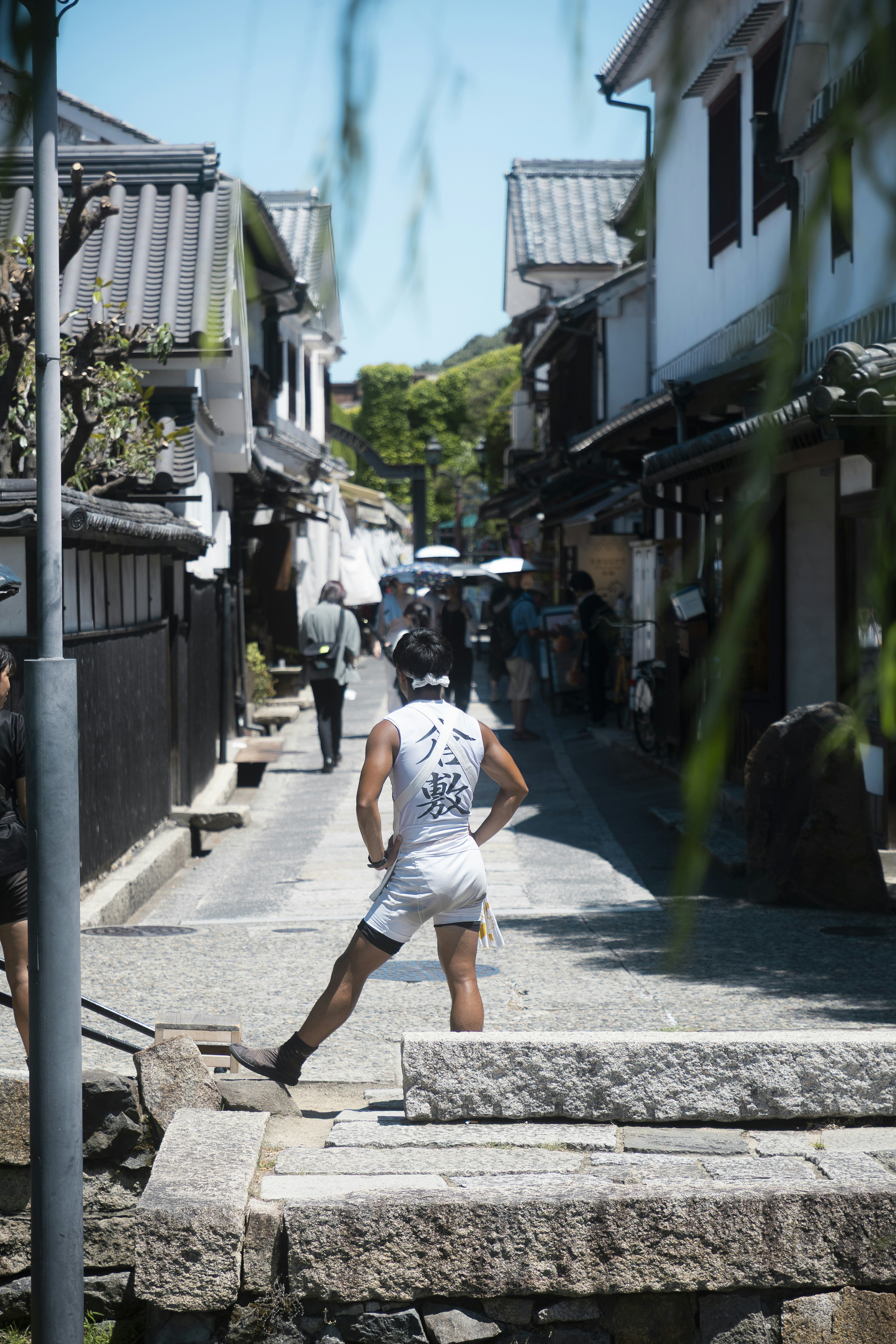 A man stretches in an old japanese street.