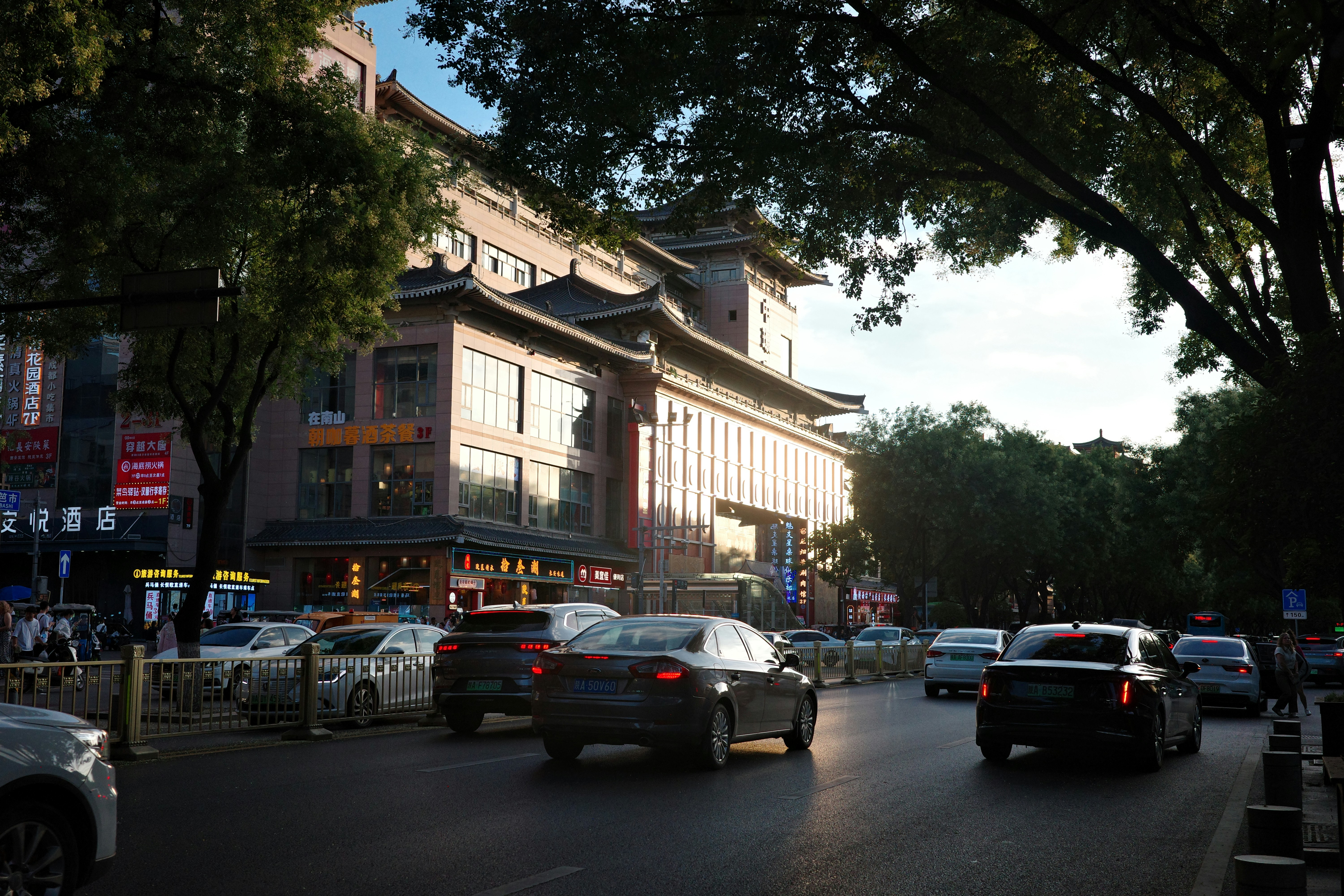Cars drive on a road in front of a building.