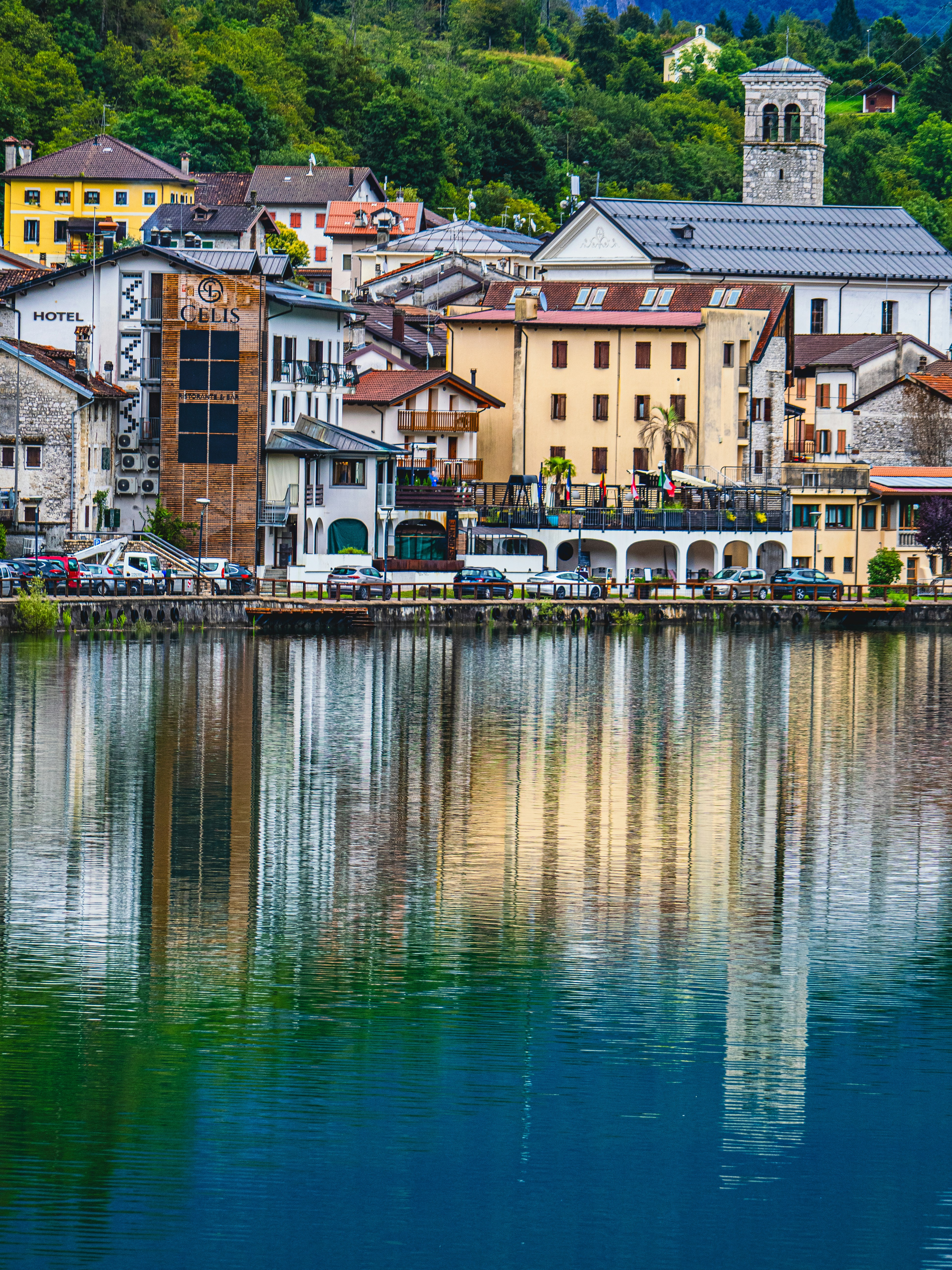 Charming lakeside village with colorful buildings and reflections in the calm water, showcasing a blend of architecture and nature.