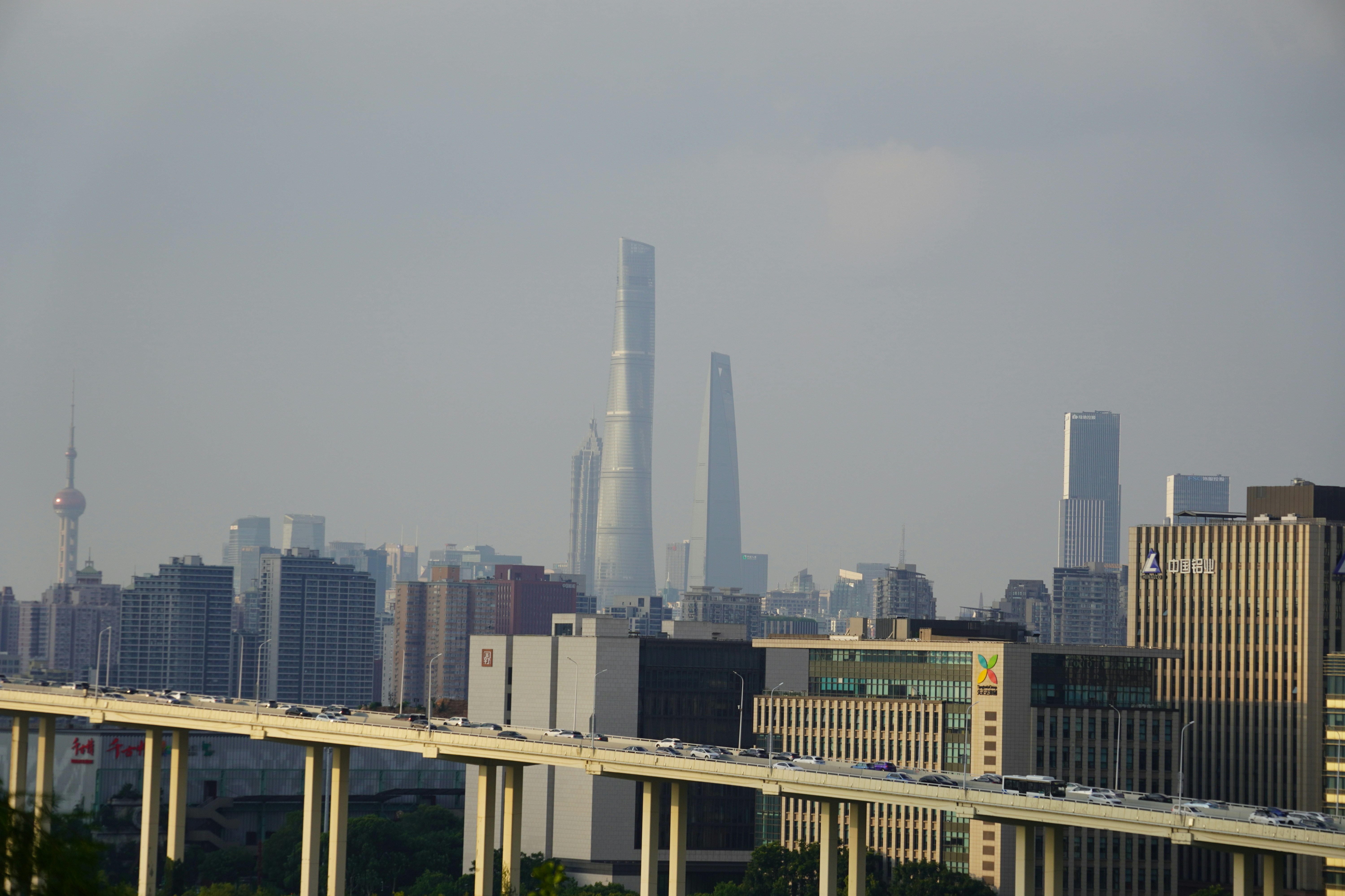 A skyline of modern buildings under a hazy sky.