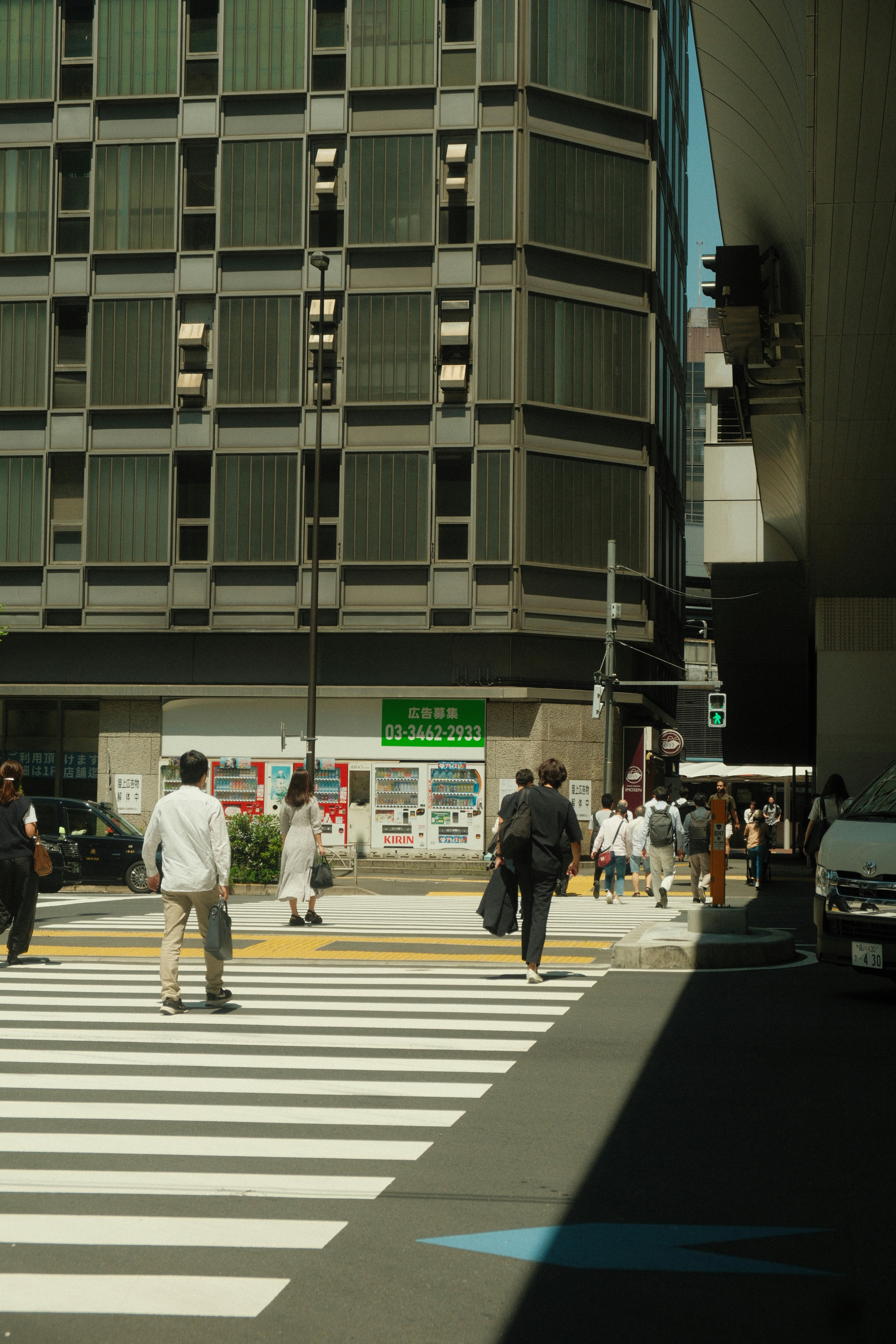 People cross a zebra crossing in a city.