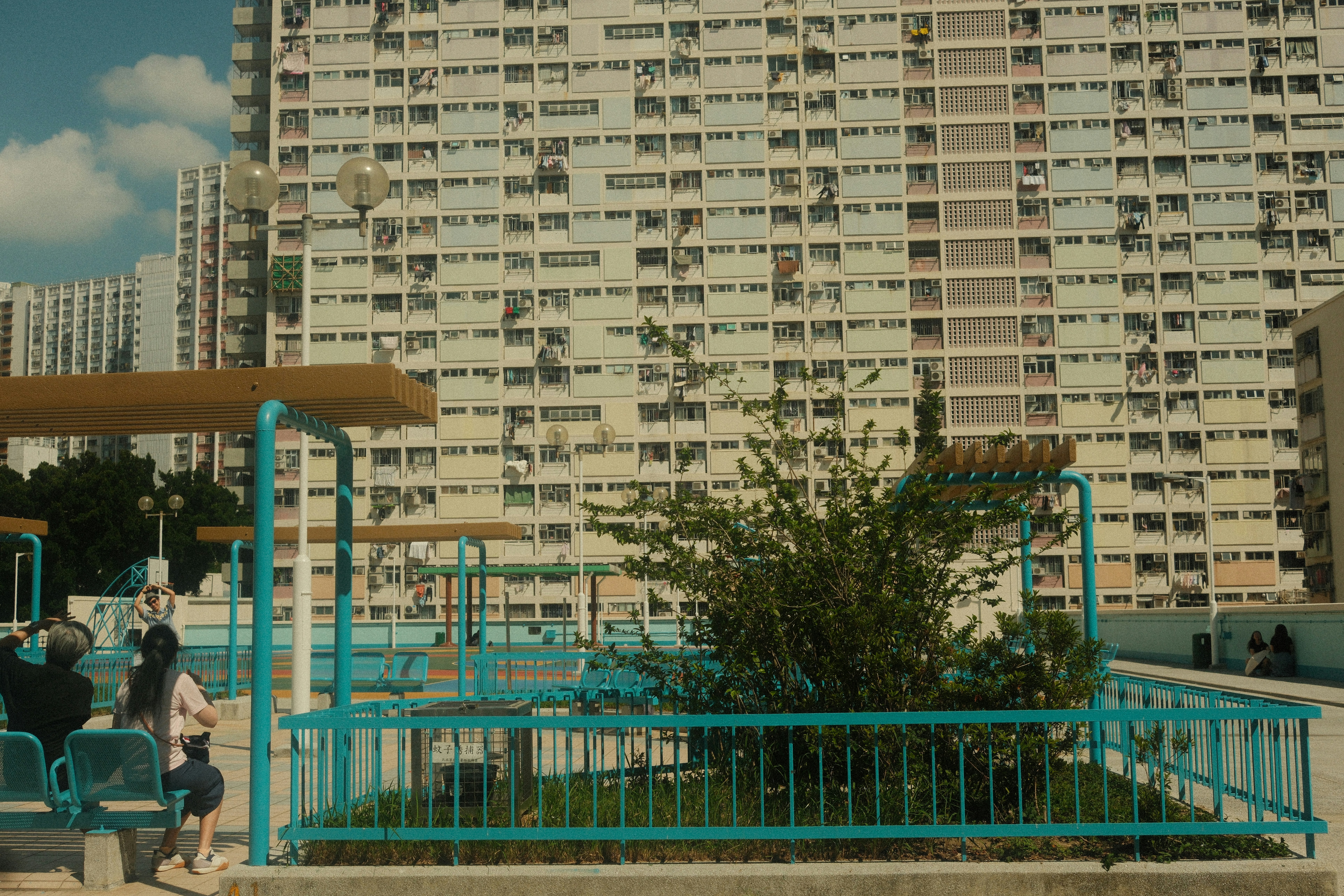 Public space overlooked by a large apartment building.