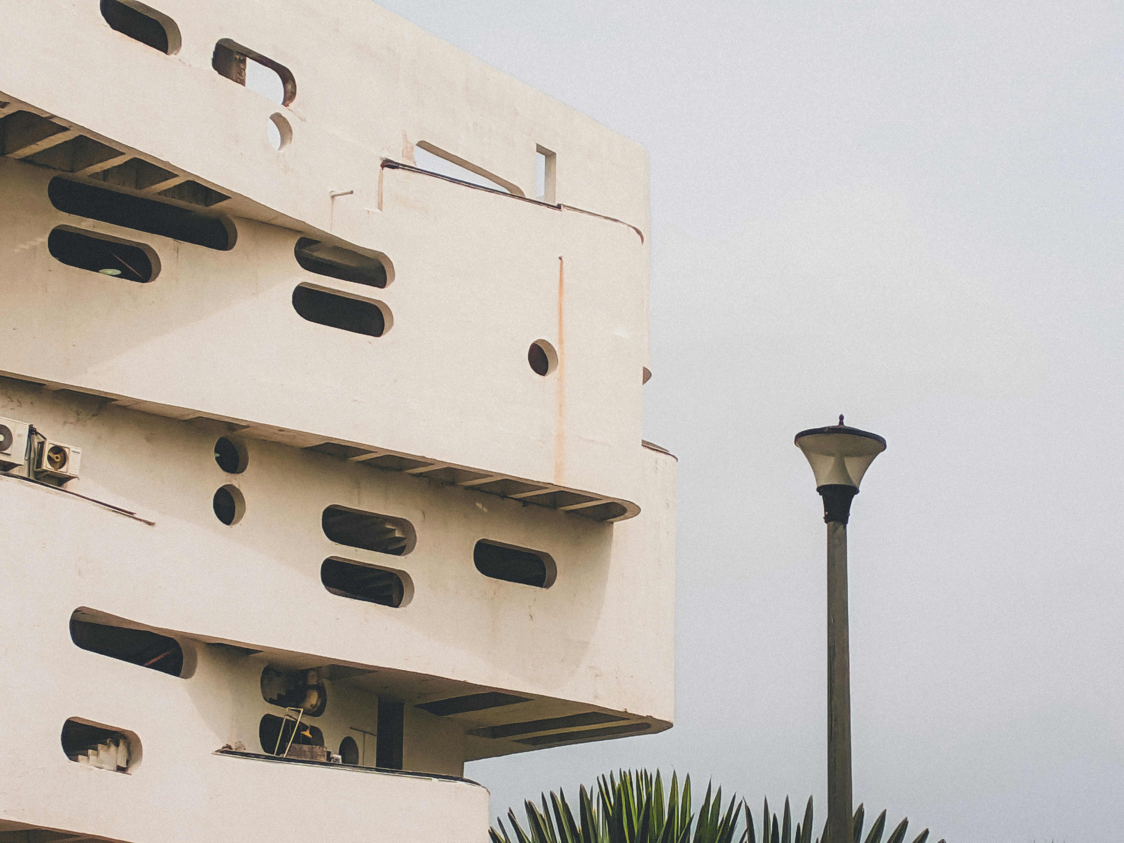 A sleek minimal modern building with clean lines and contemporary architectural style. | Modern building's architecture with a street lamp.