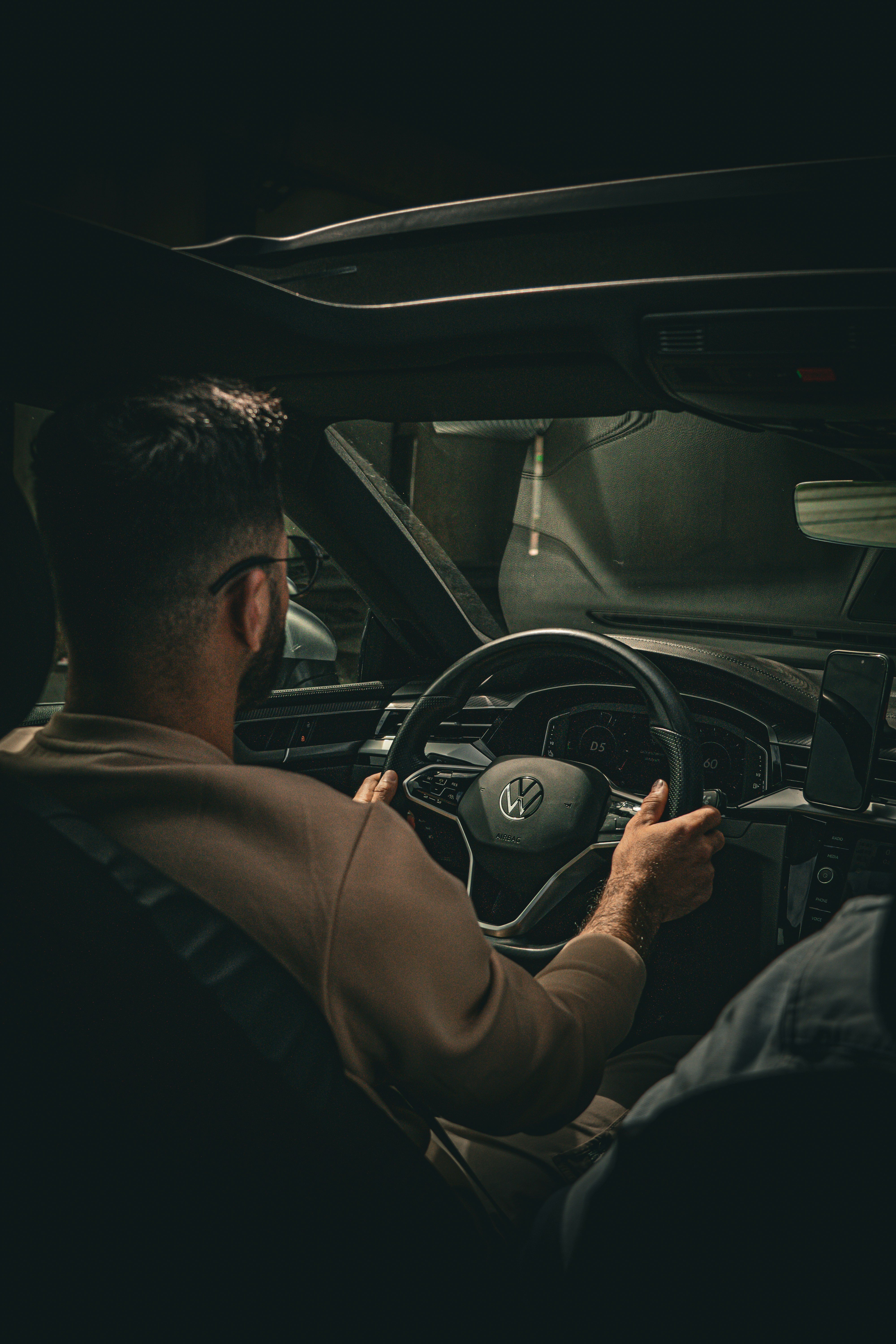 A man is driving a volkswagen car.