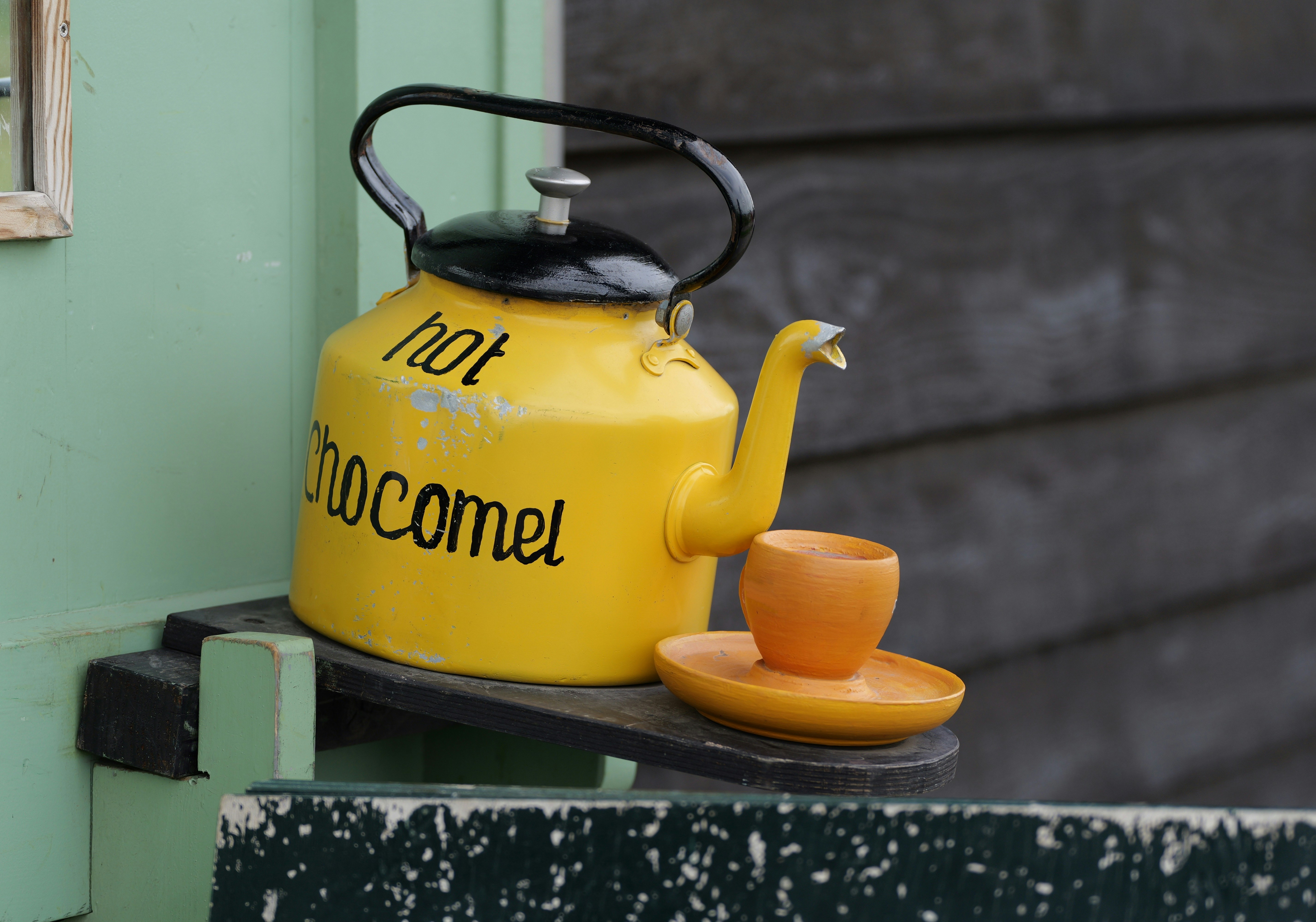 A miniature kettle and cup sit outside.