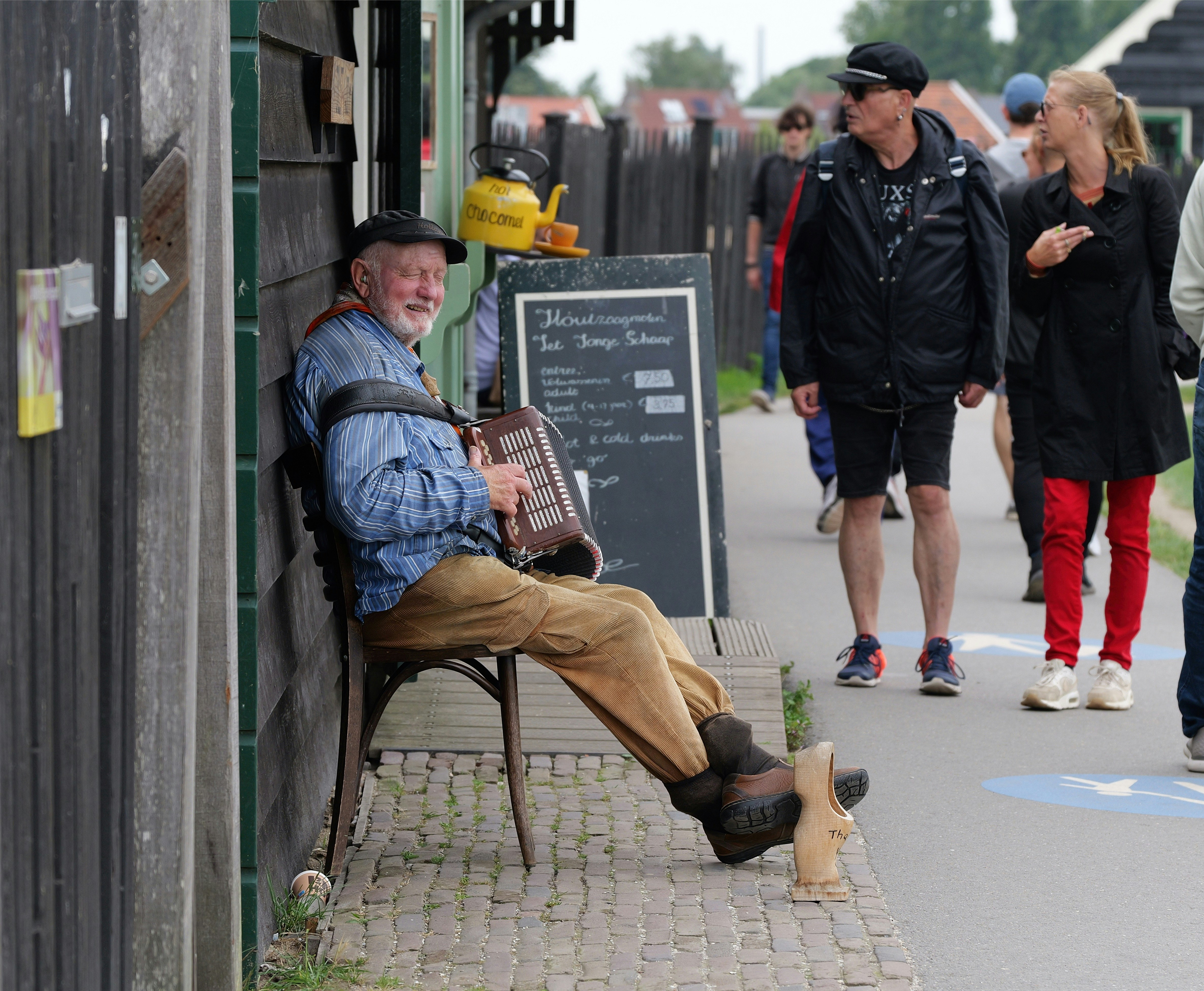 Street musician, editorial | Accordion player entertaining tourists outside.