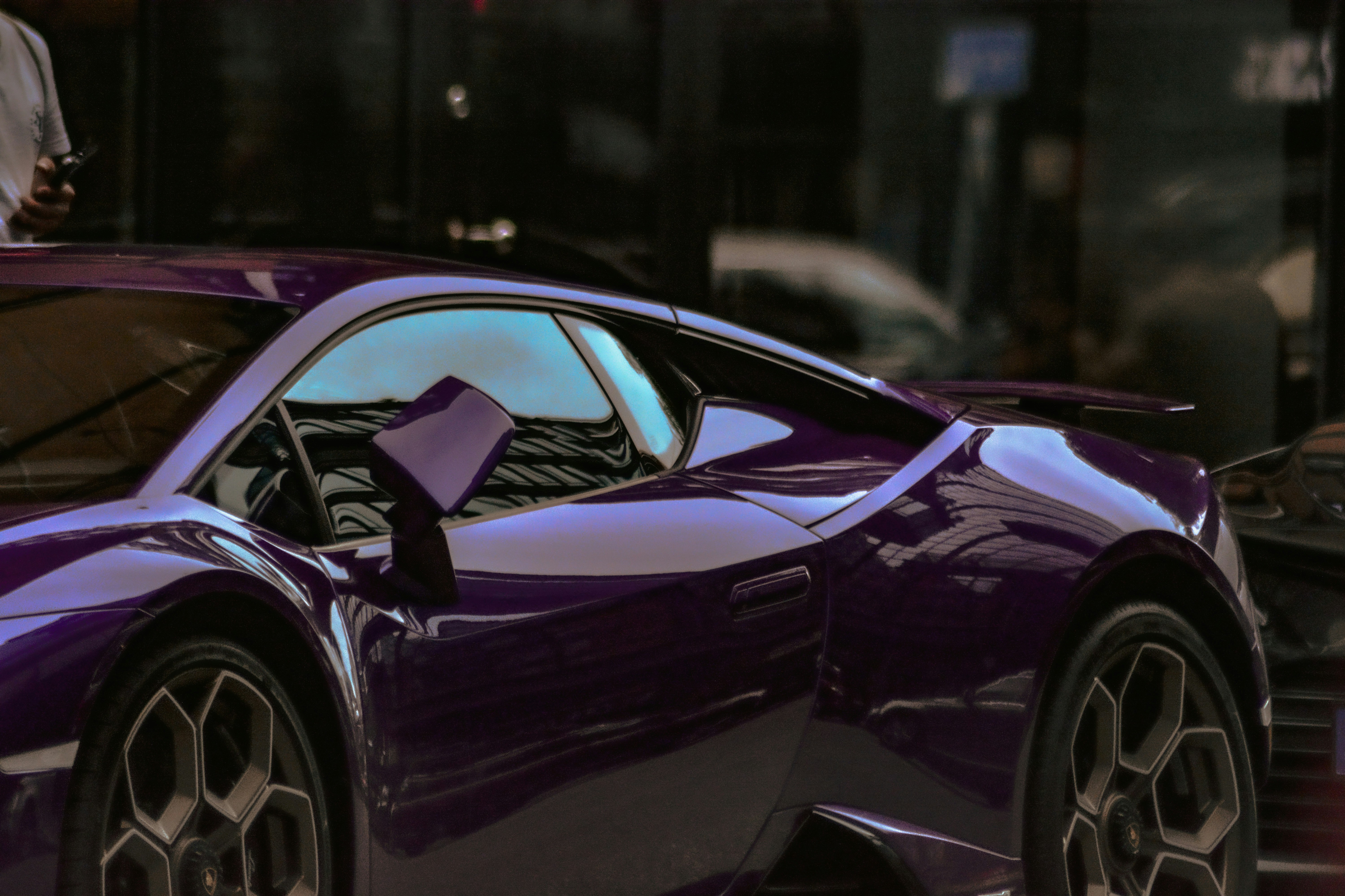 A purple sports car is parked on a city street.