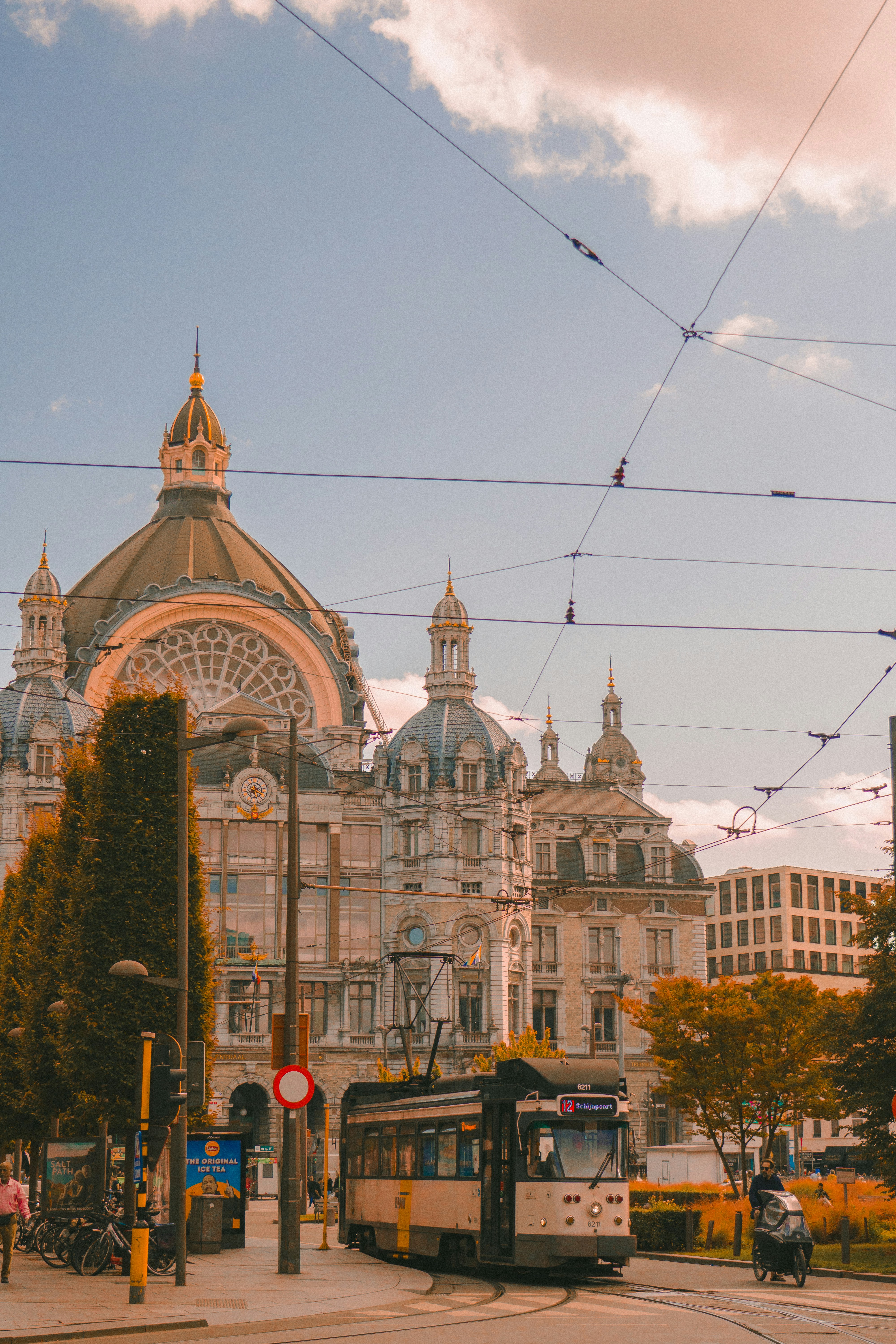Historic tramway beneath a grand city cathedral under a pastel sky