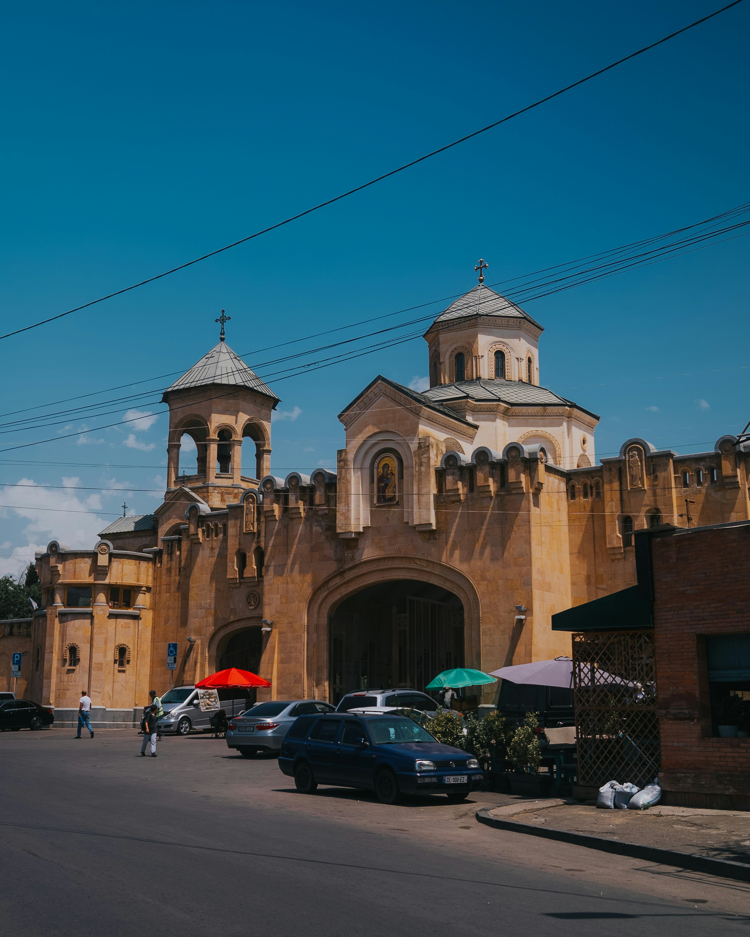 A yellow church stands prominently under a blue sky.