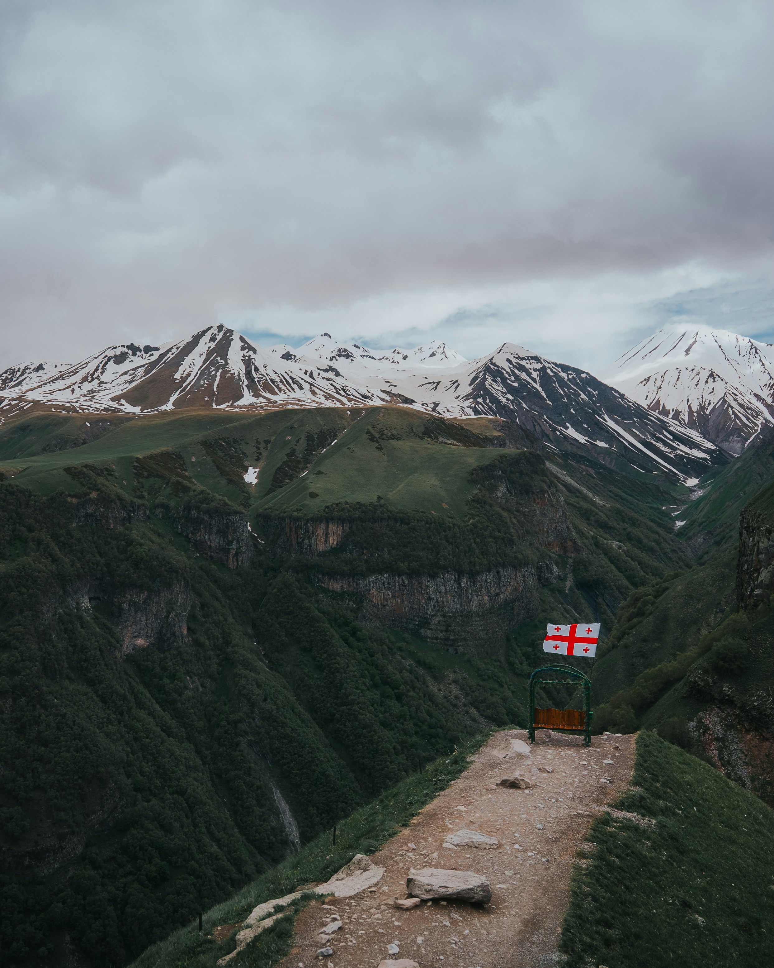 Georgian flag overlooks a scenic mountainous vista.