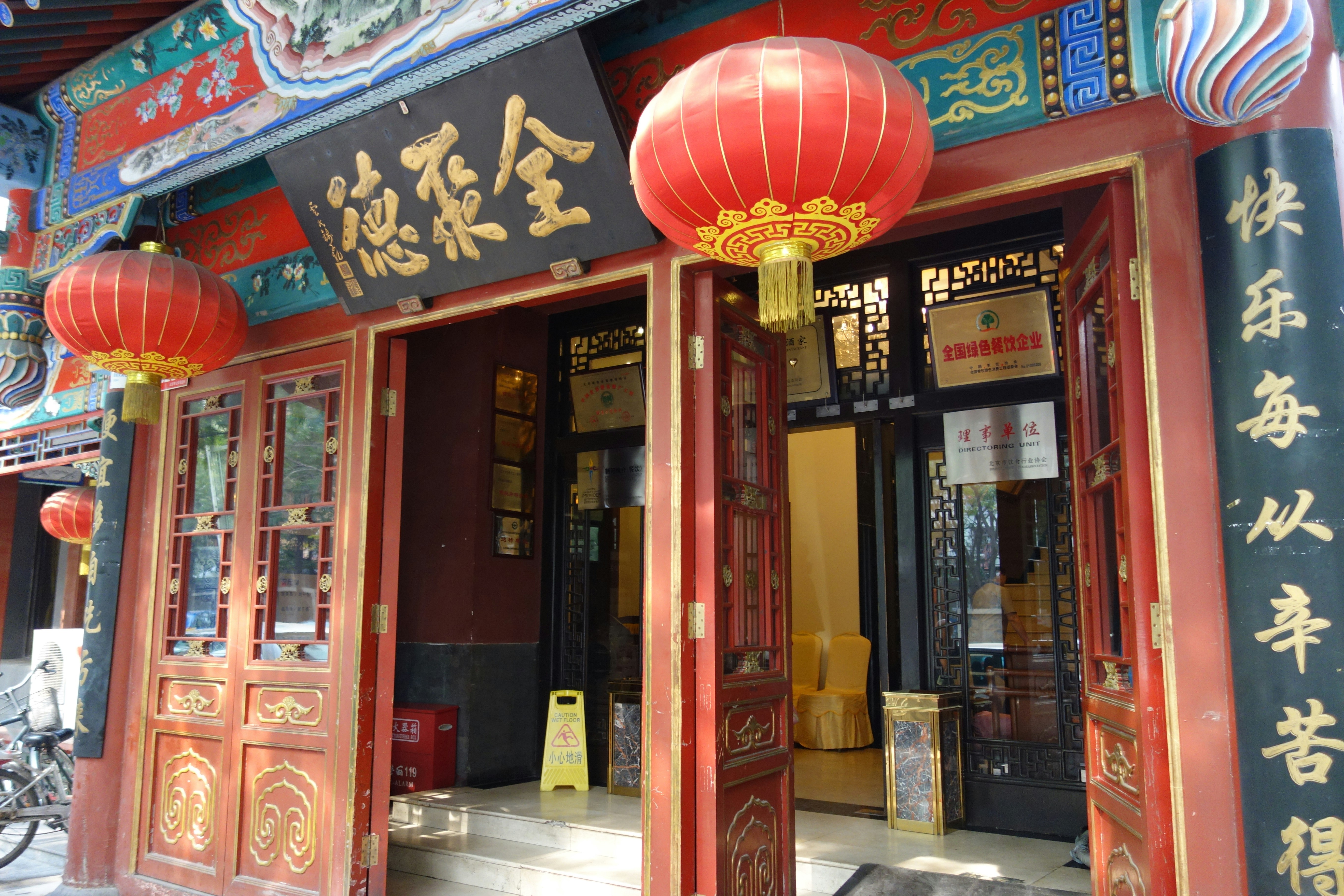 A chinese building with red lanterns and doors.