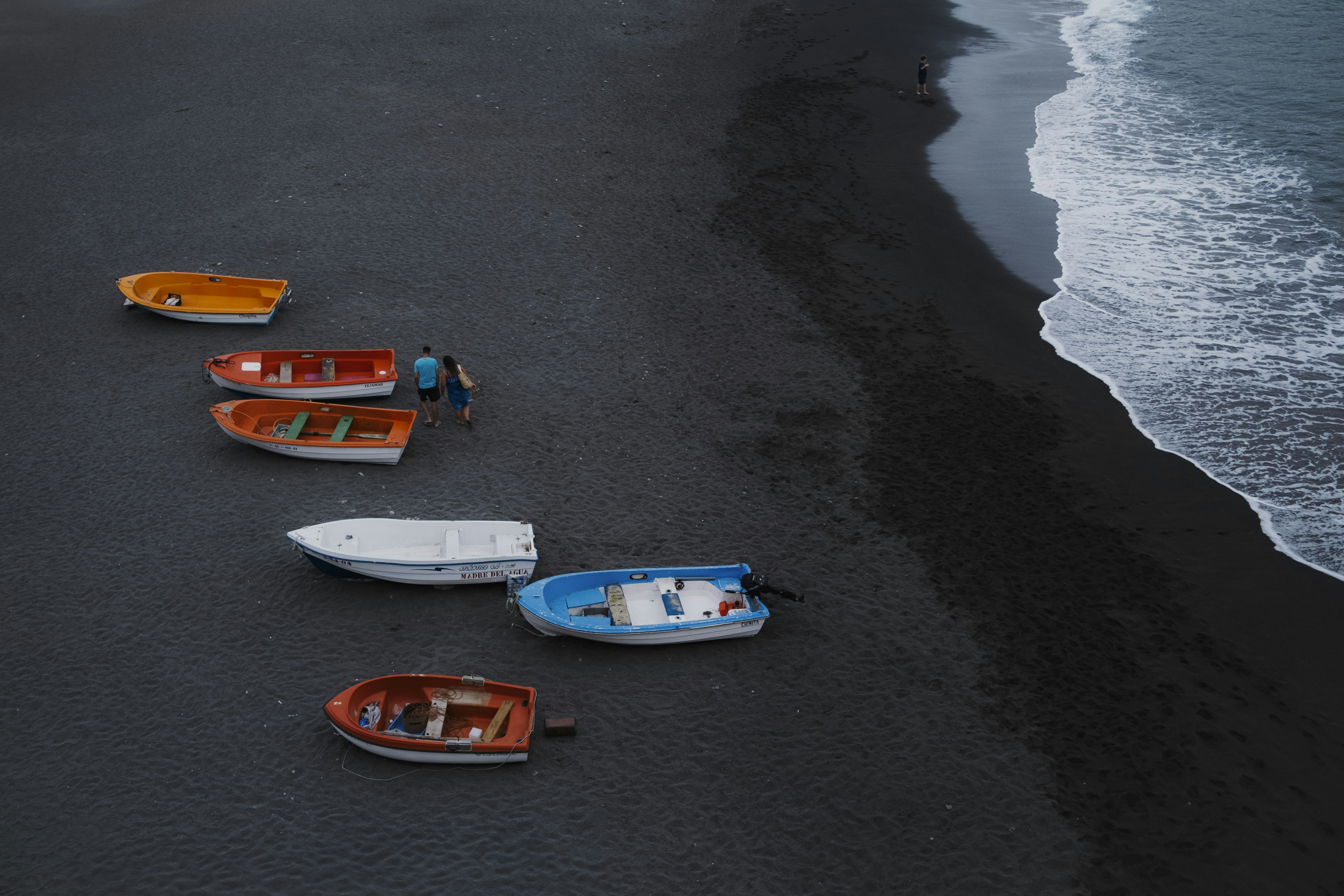 Colorful boats are parked on a dark beach.