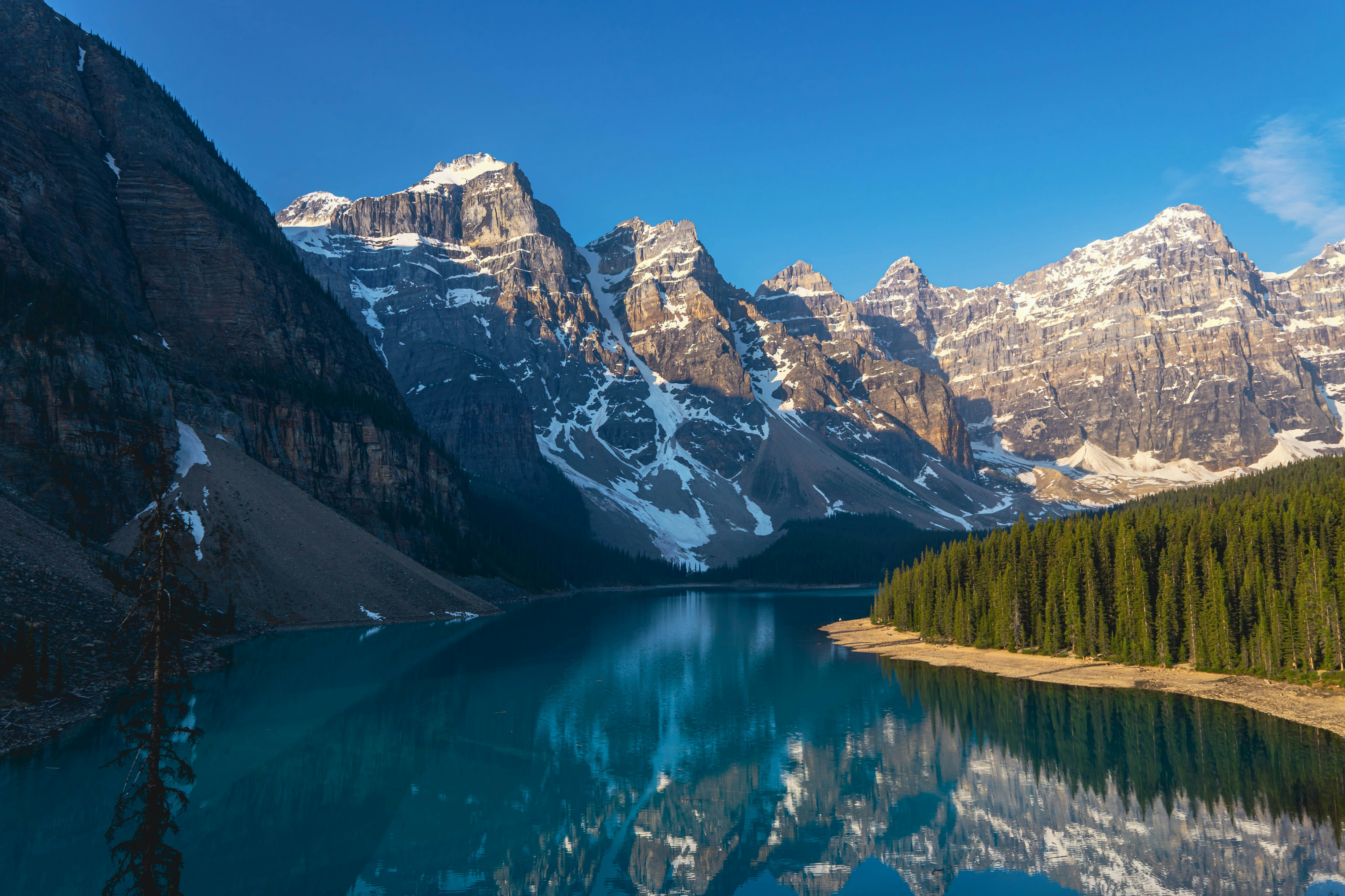 Mountains and lake reflect under a blue sky.
