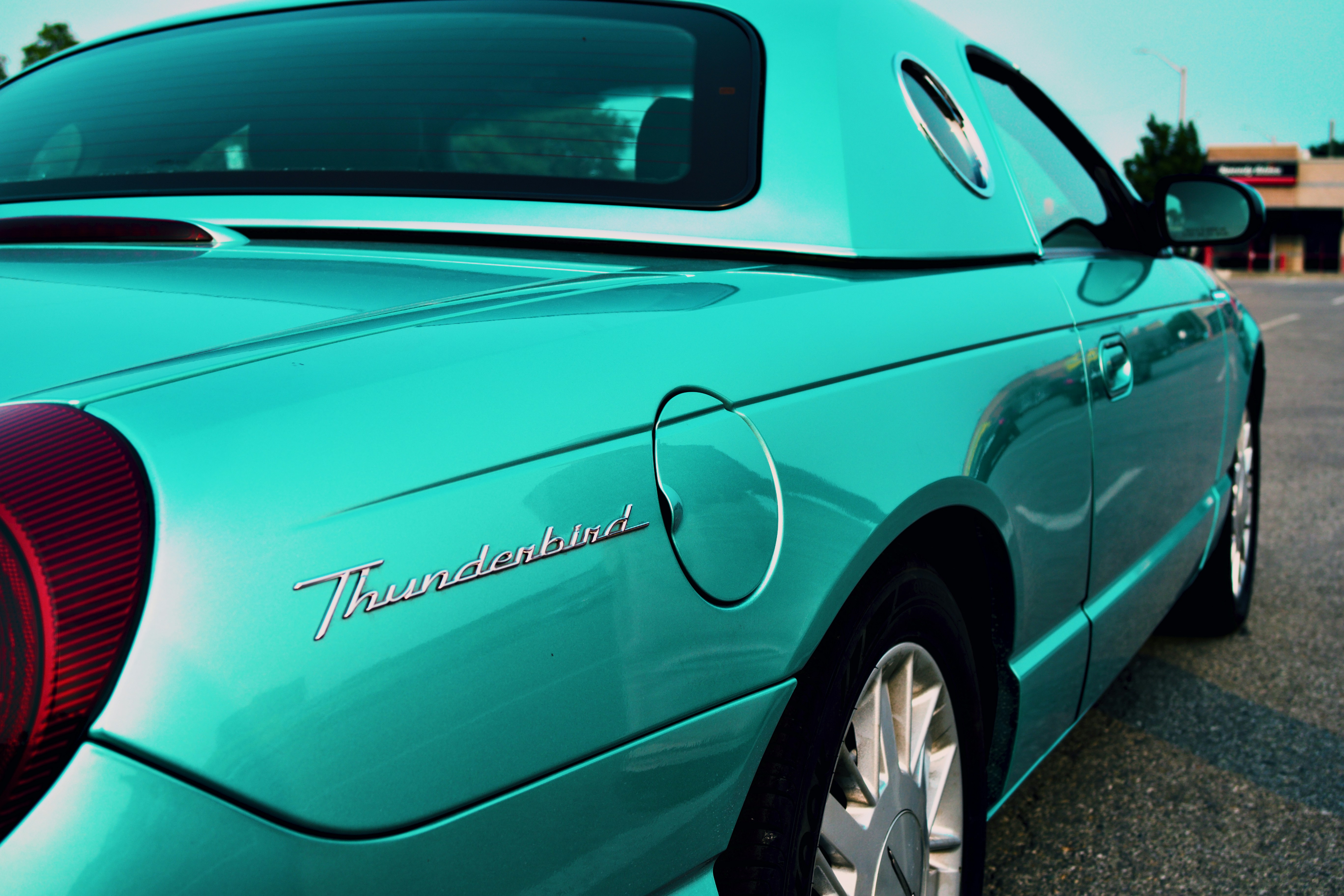 2002 Ford Thunderbird | A turquoise thunderbird shines in the afternoon.