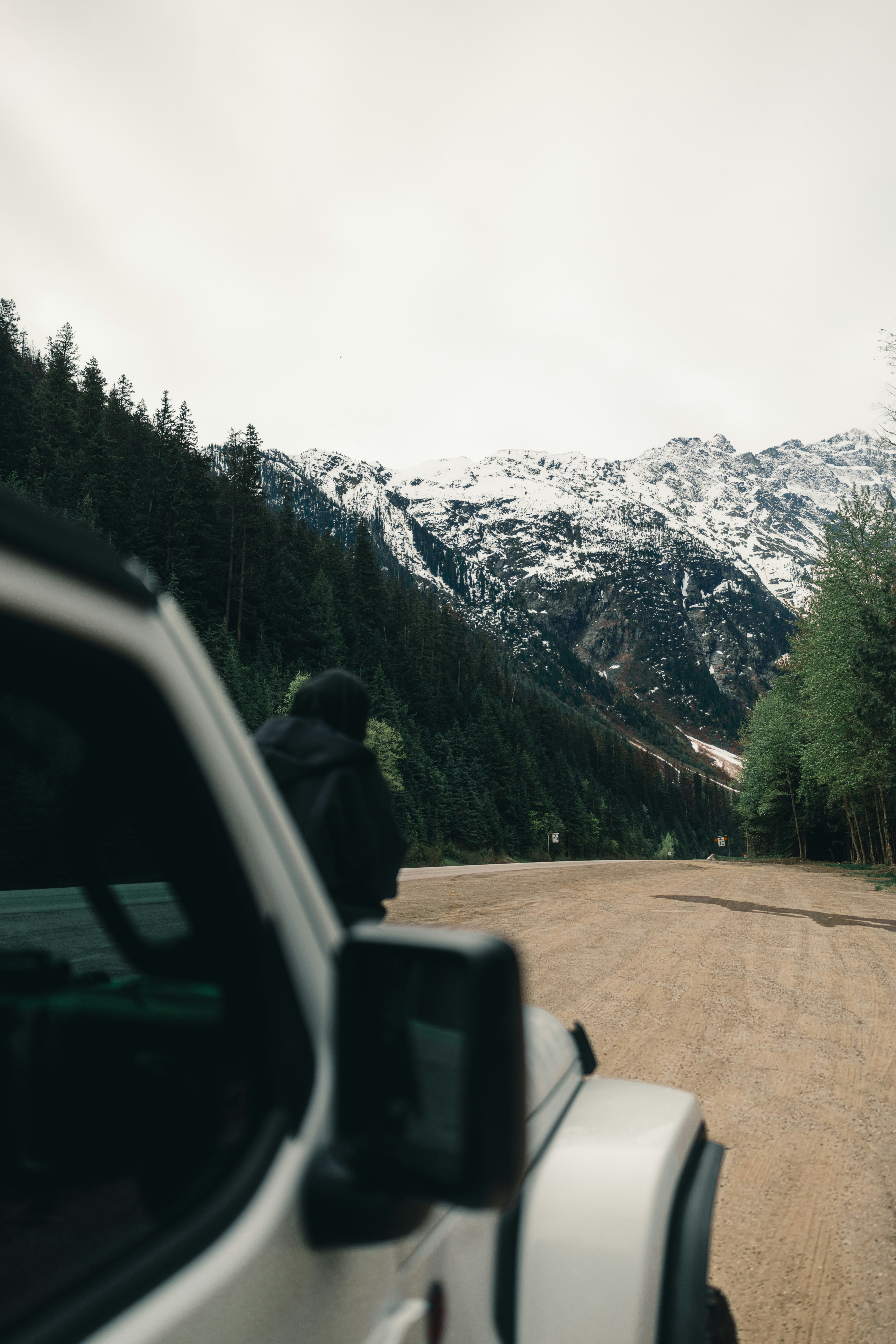 Person and jeep overlook a snowy mountain range. photo – Free Forest ...