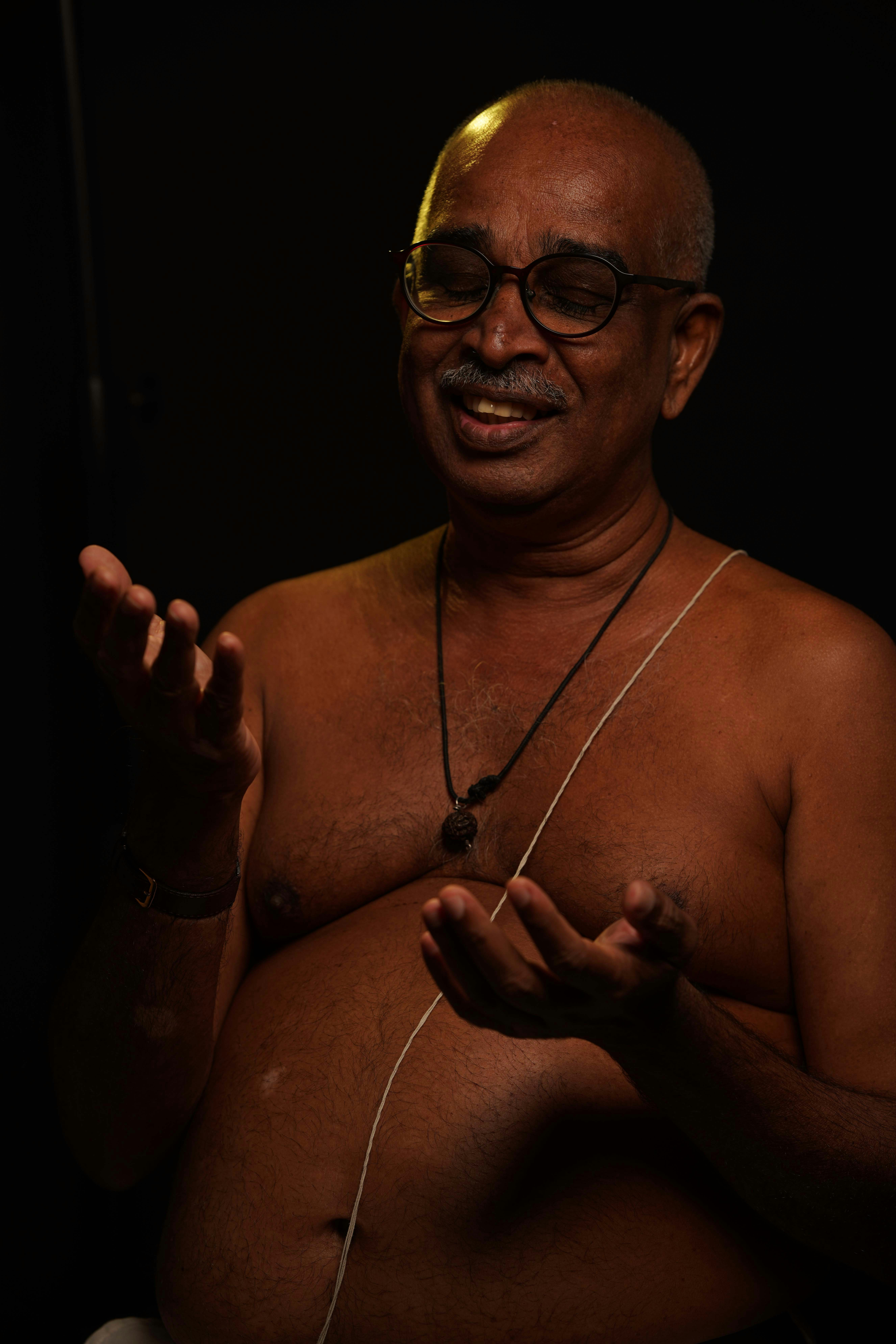 Vishnu Vasu : Sri Lankan writer, Editor, Storyteller | A smiling man with glasses and open arms.