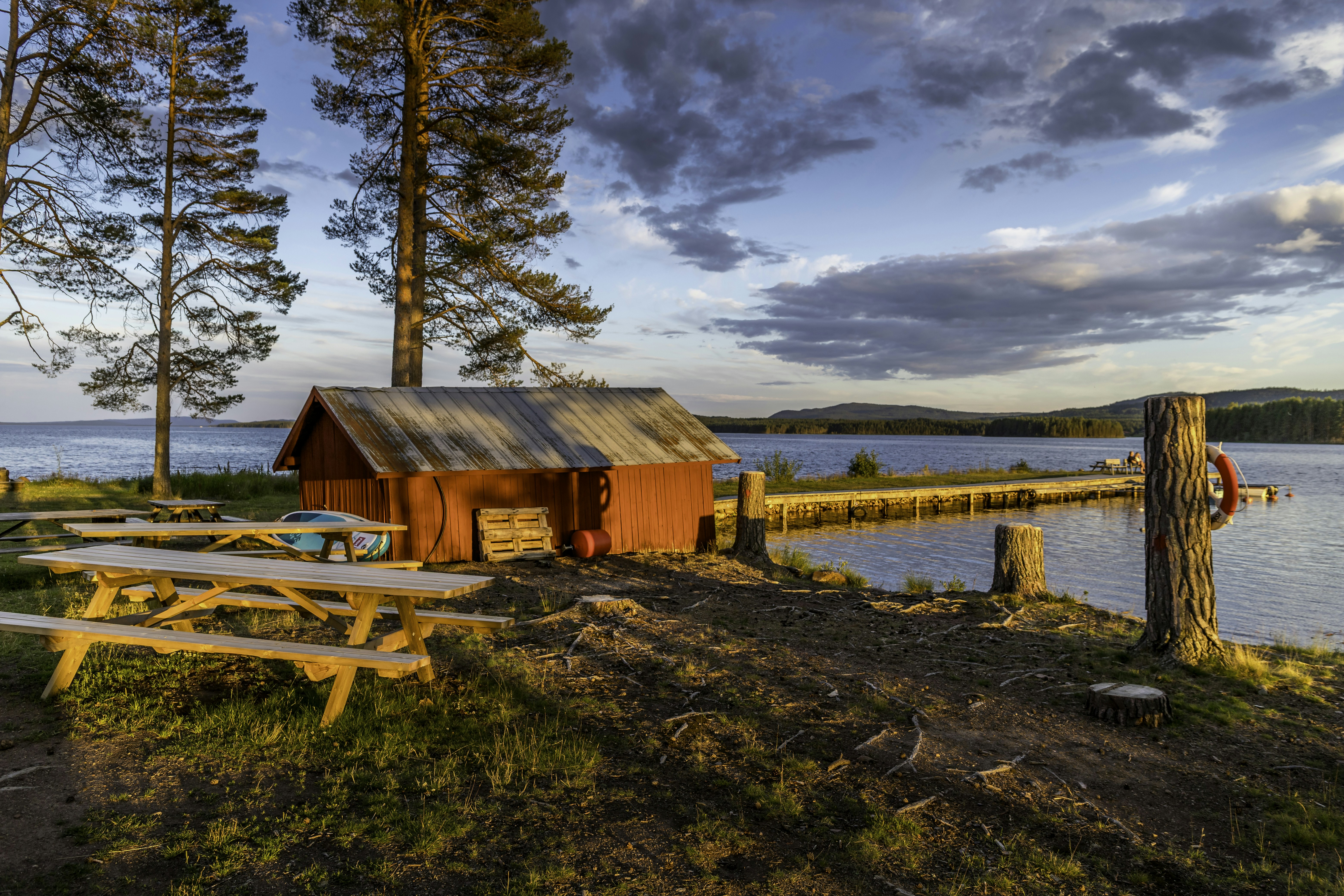 Late afternoon near Mora/Sweden | Red shack on a lake with a pier.