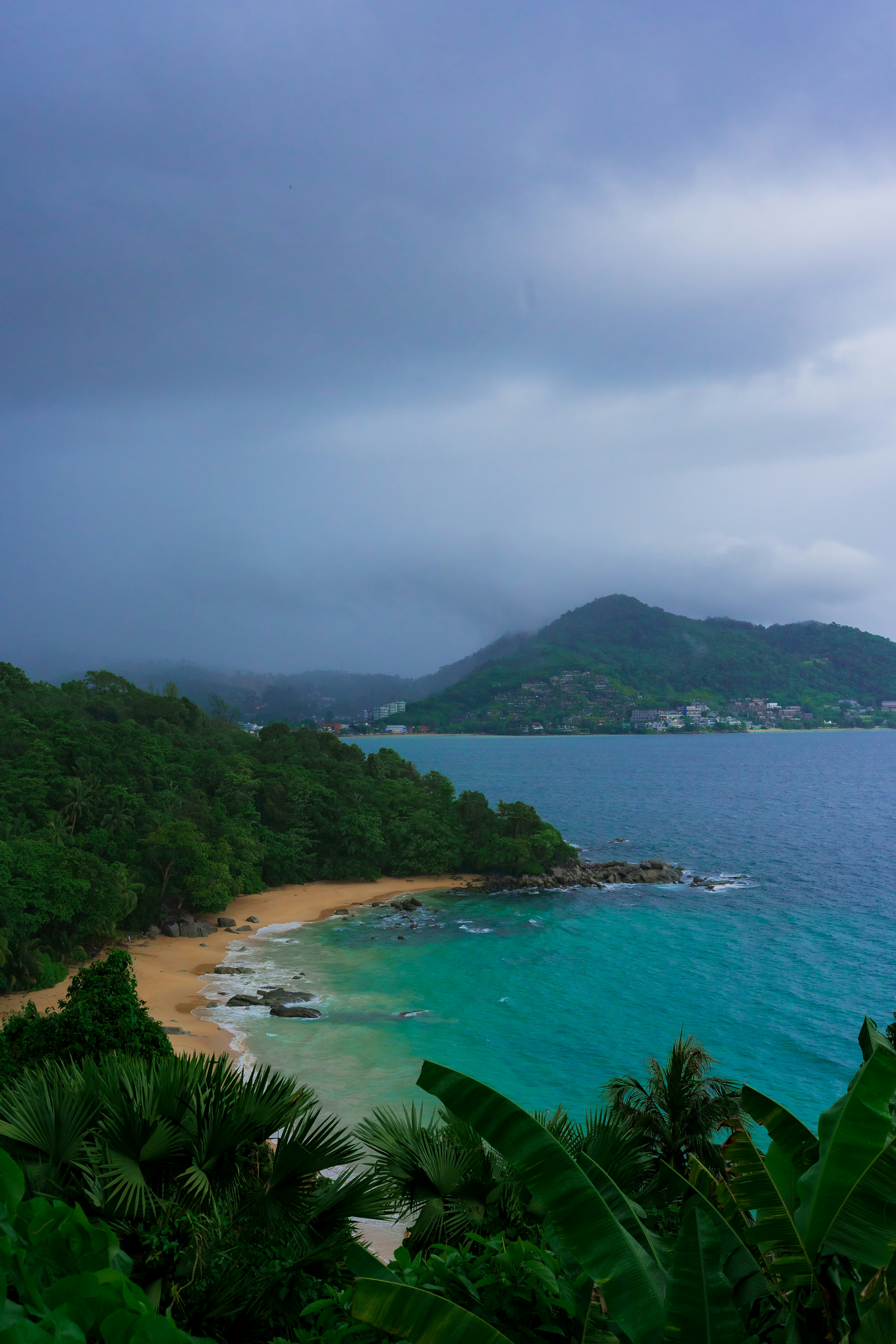Turquoise Shoreline Framed by Jungle and a Looming Cloudscape