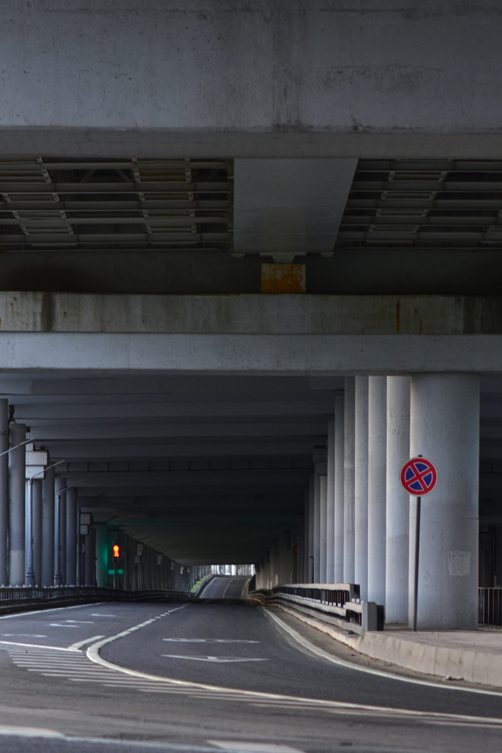 An underpass with concrete columns and road.