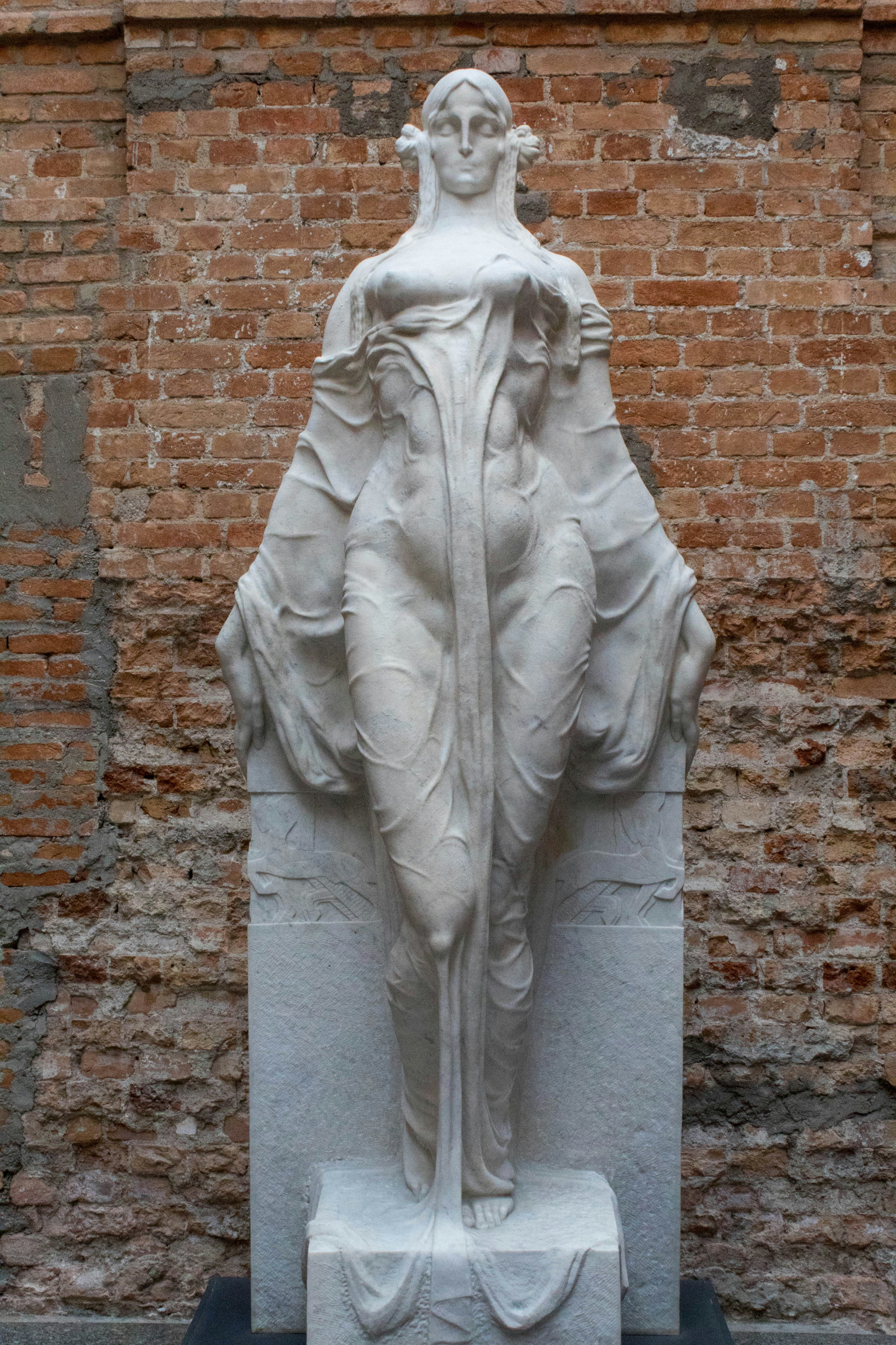 A marble statue of a woman stands tall.