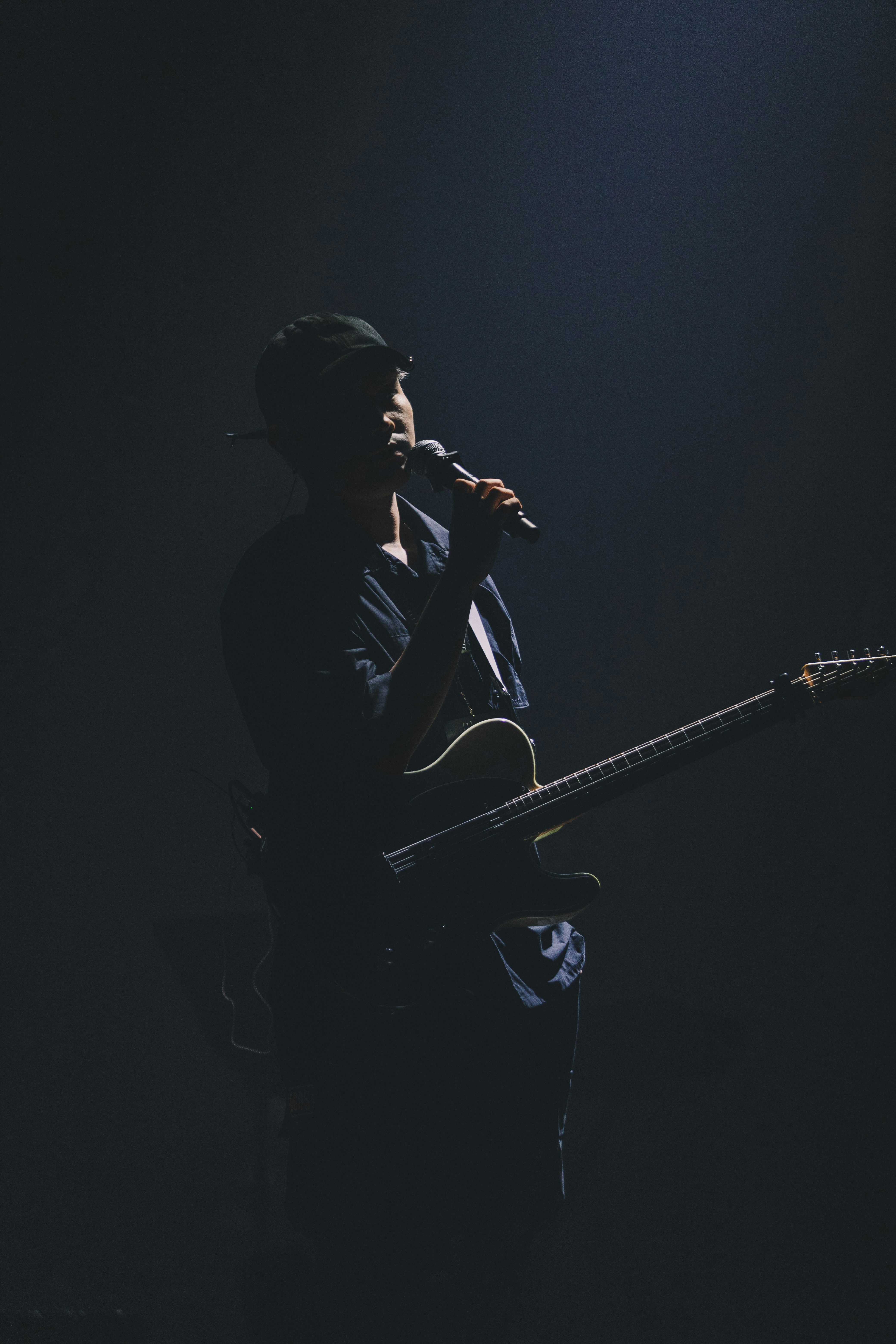 A musician is playing guitar and singing.