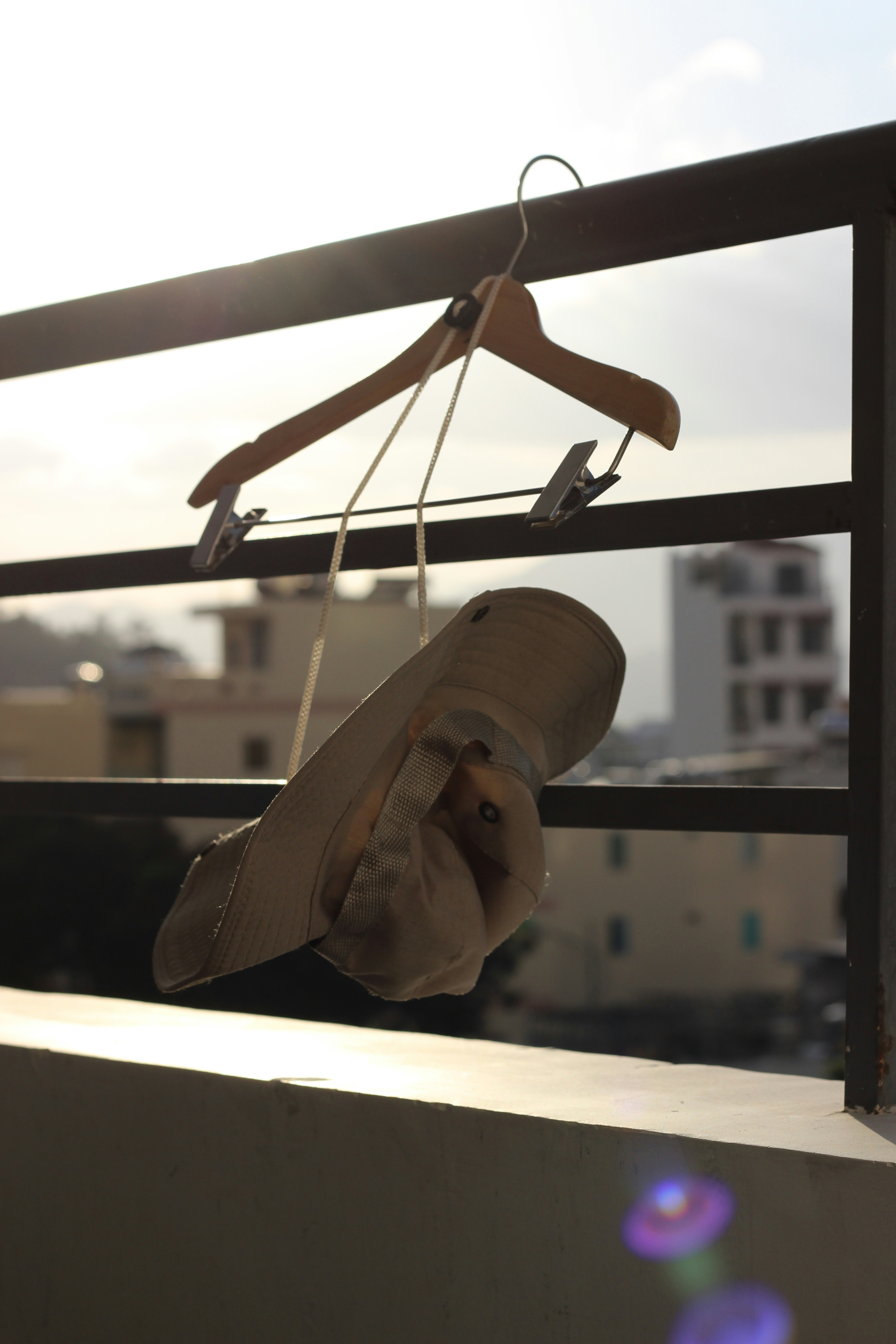 A hat hung on a hanger outside.