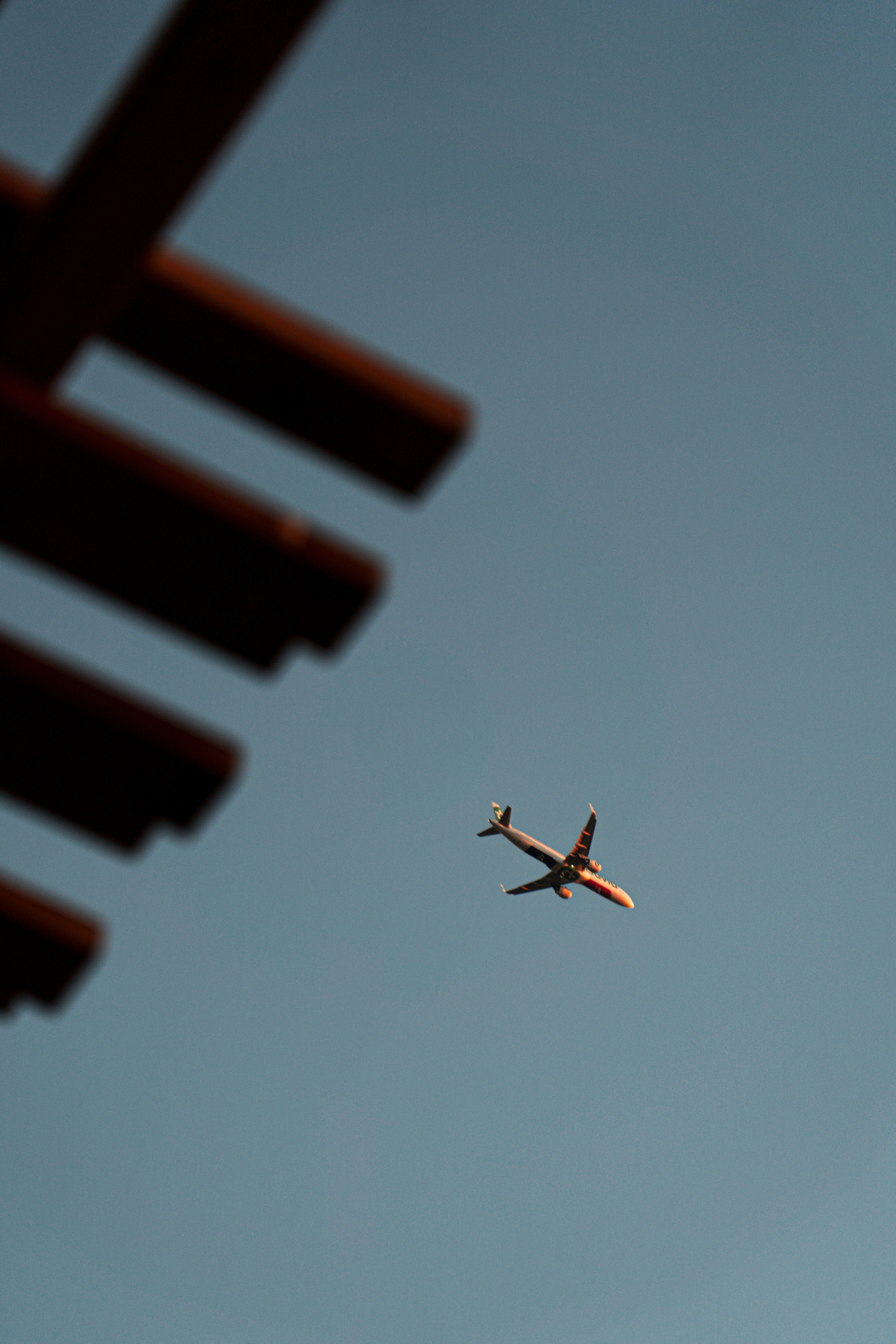 An airplane flies across a clear blue sky.
