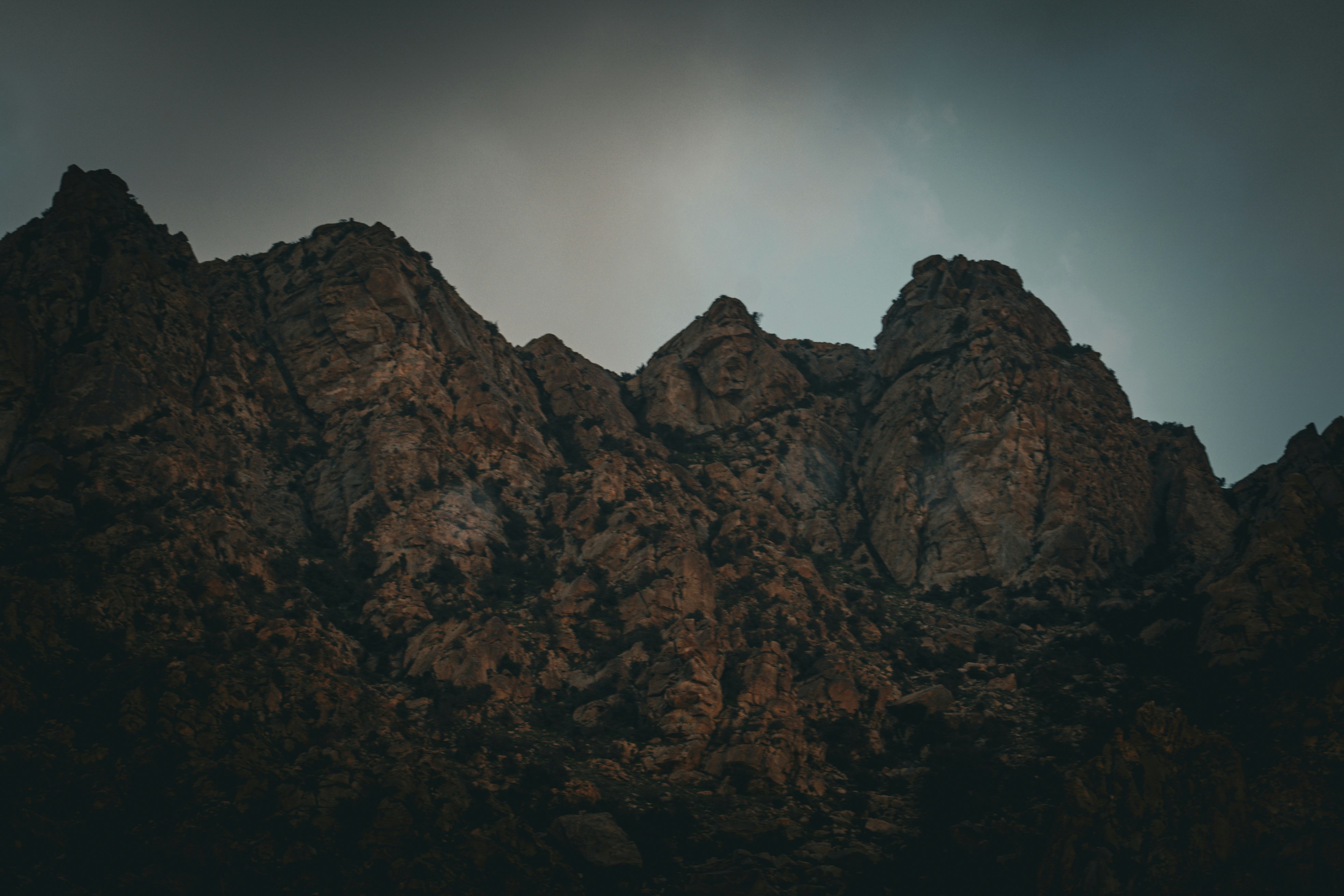Dramatic mountain peaks under a cloudy sky.