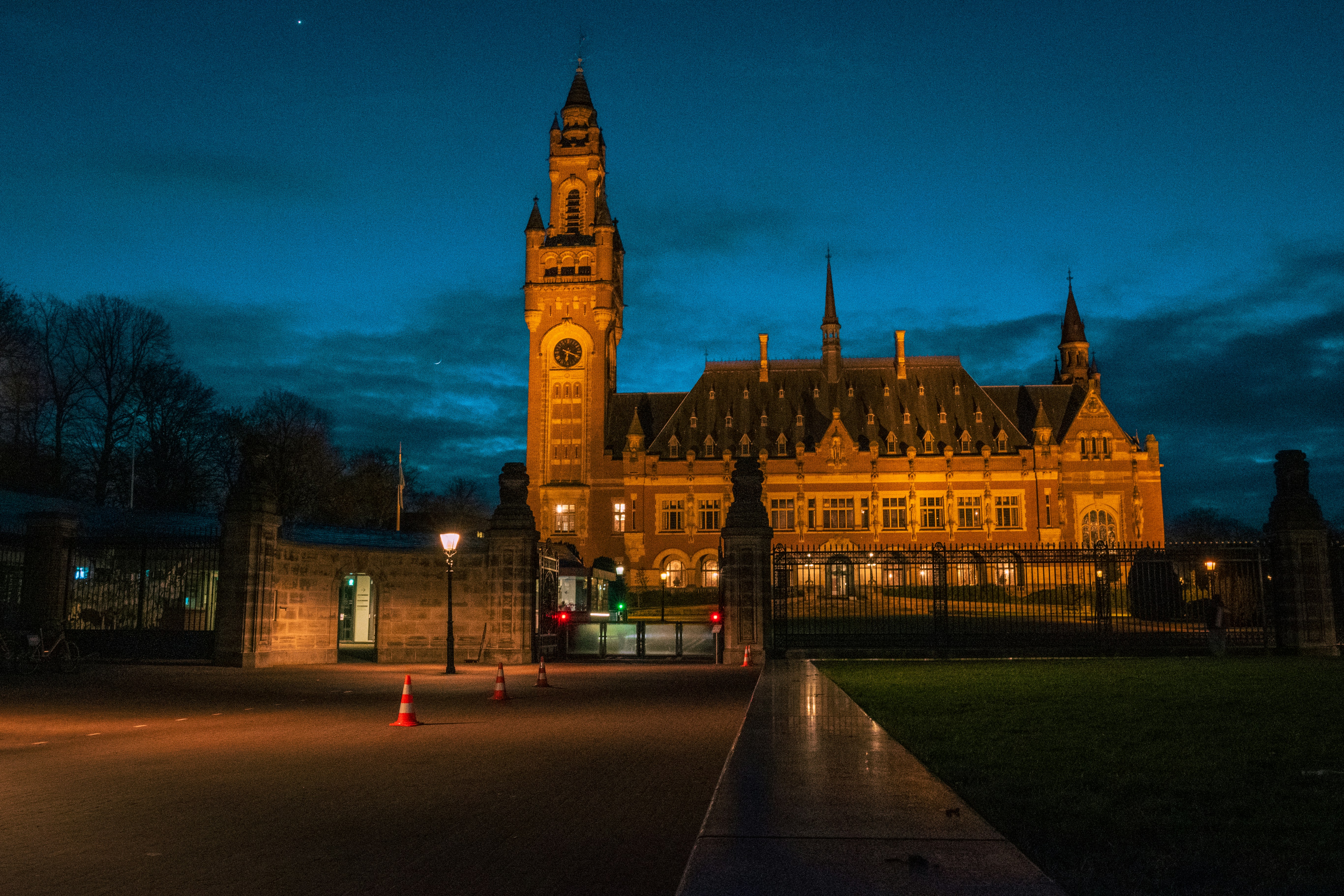 The peace palace glows at dusk in the hague.
