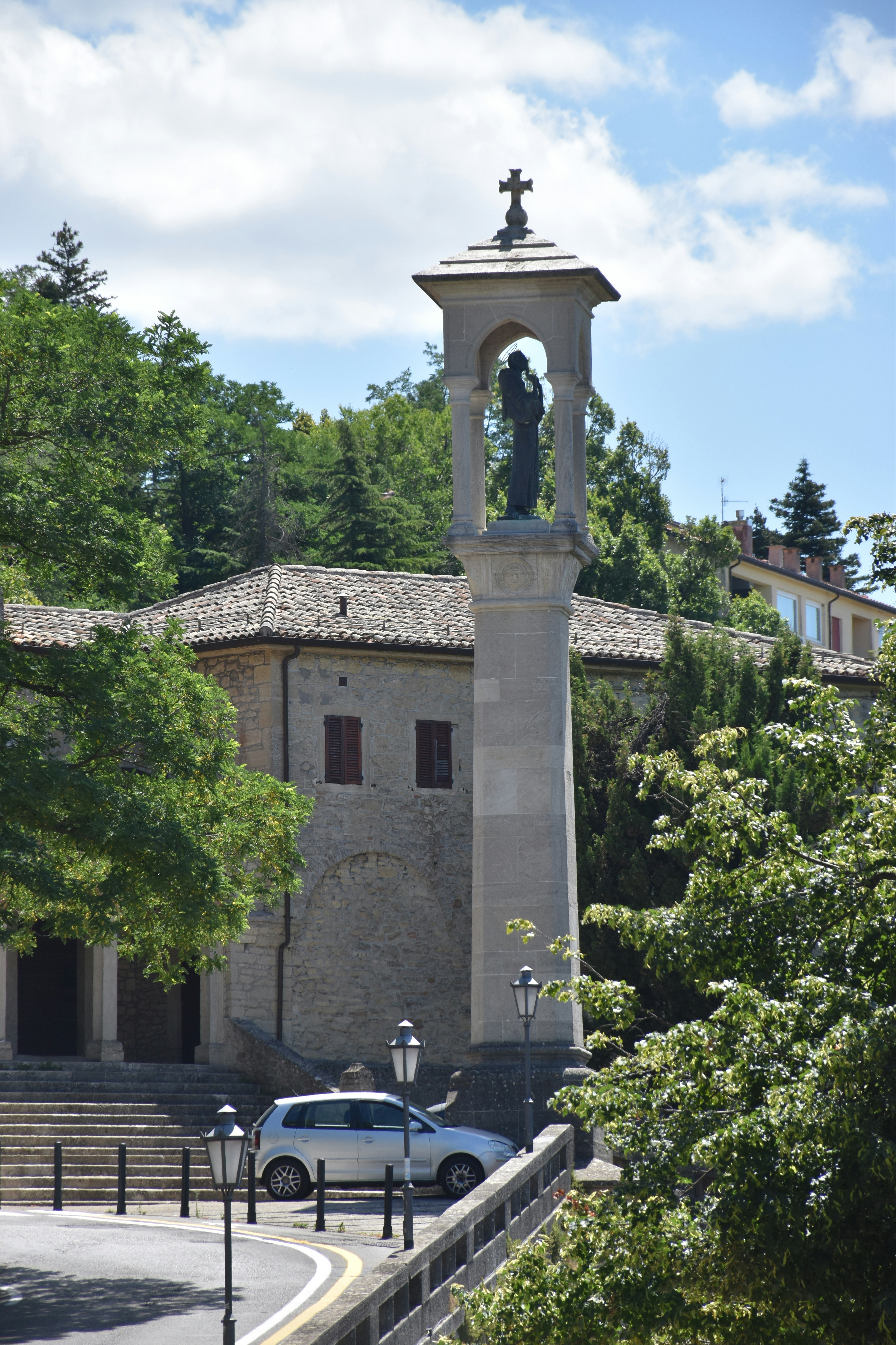 An ancient religious building with a sculpture and car.