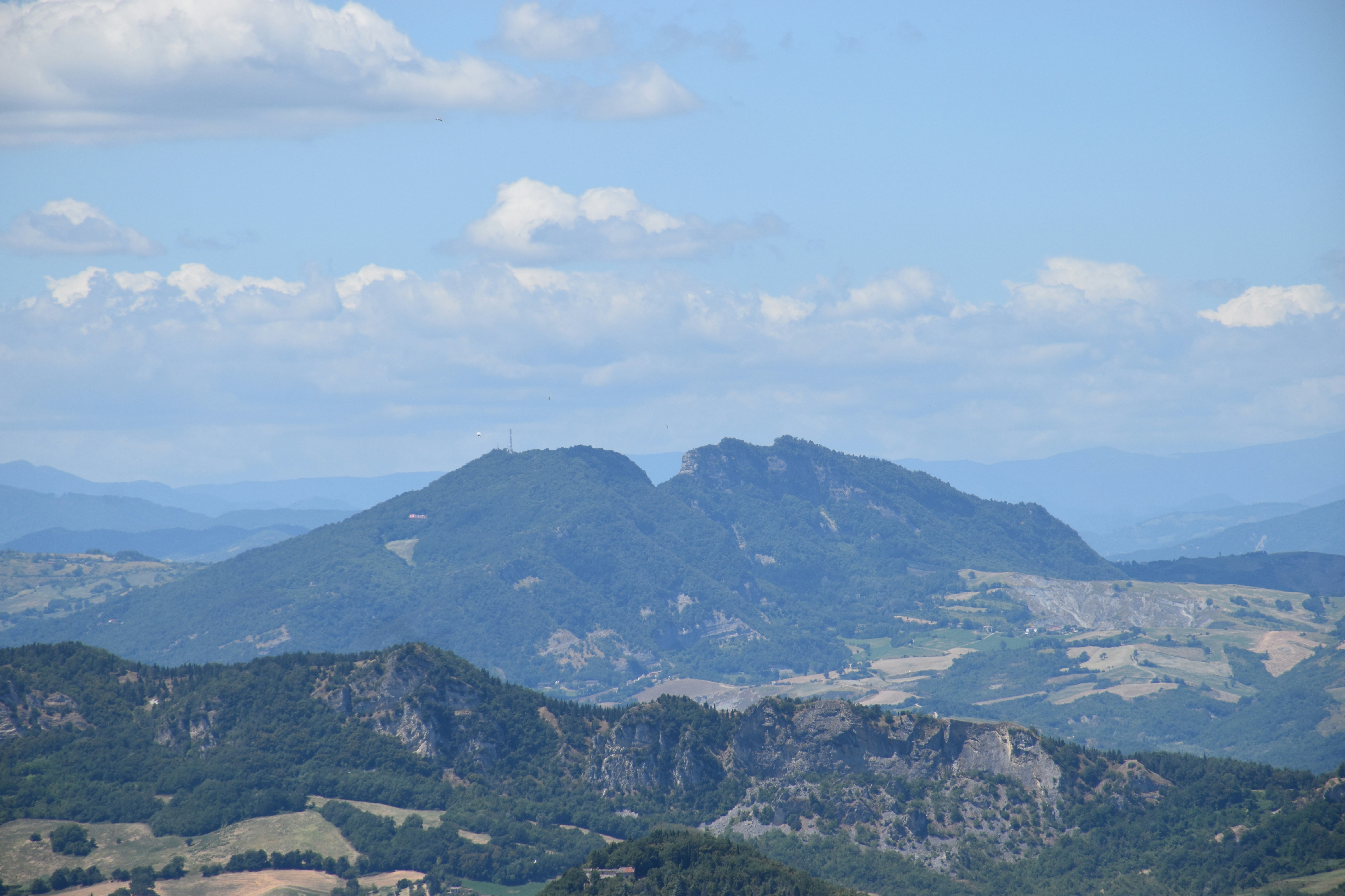 Mountains rise against a cloudy, blue sky.