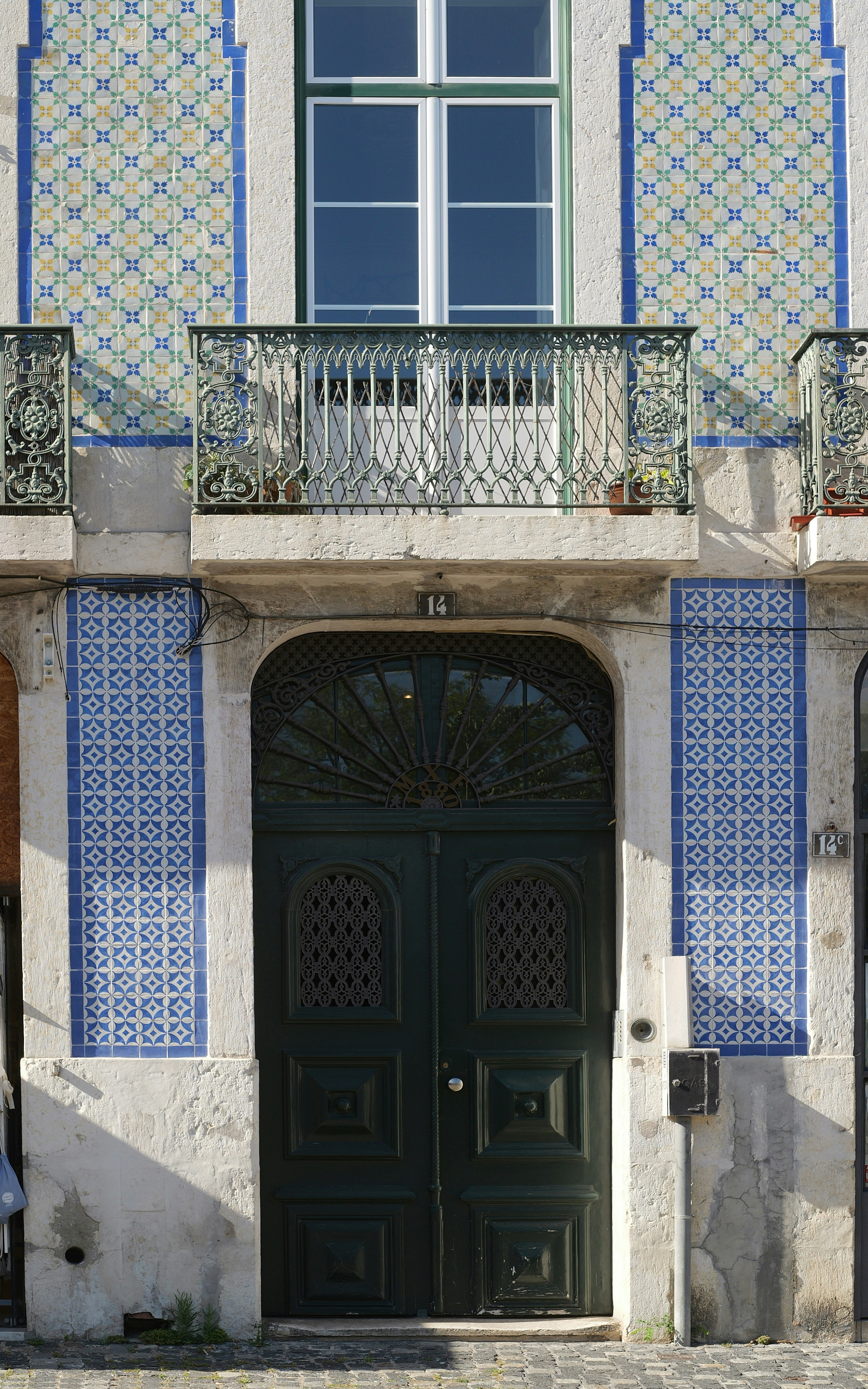 Lisbon, old architecture | Ornate door and window with patterned tile exterior.