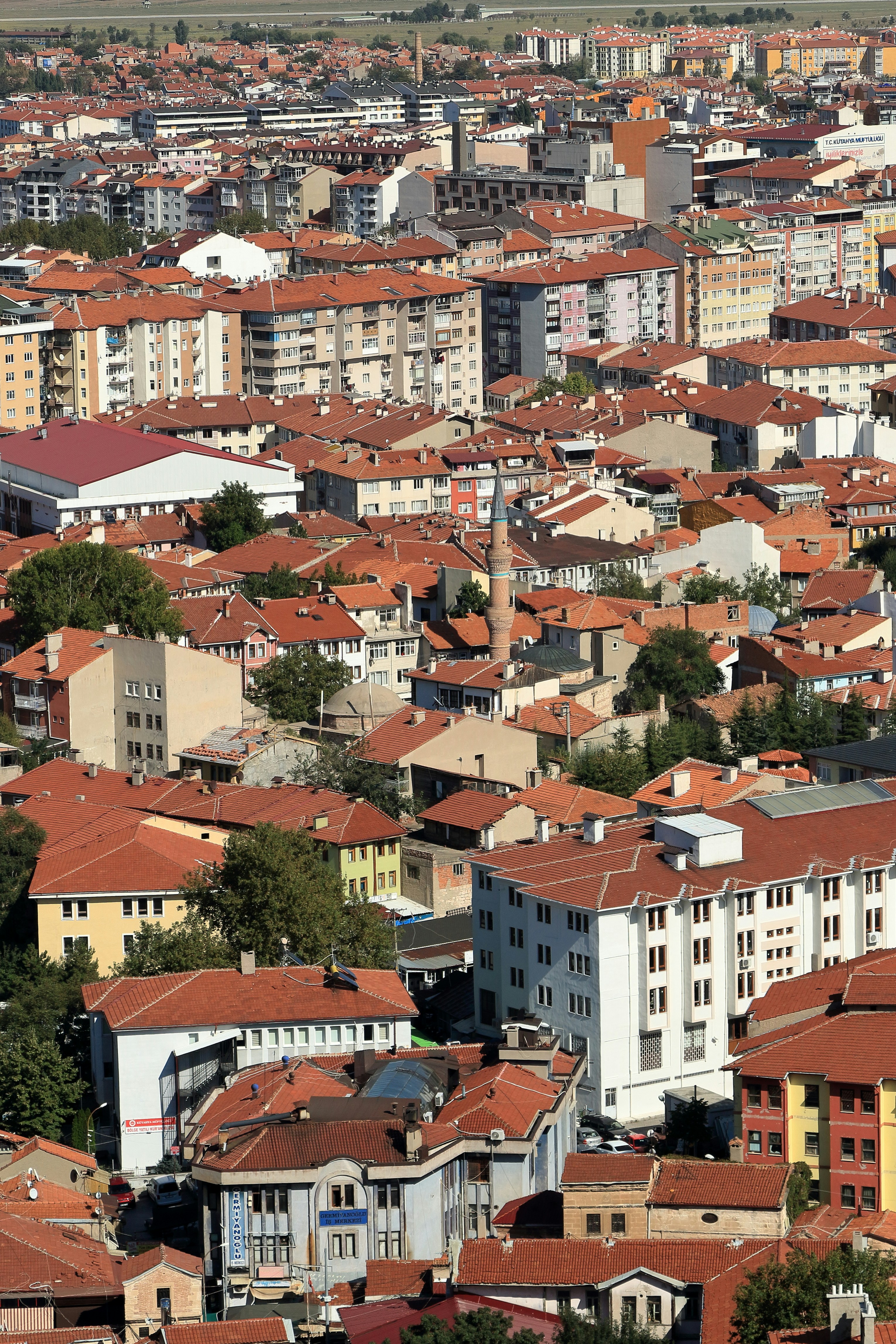 Cityscape with many buildings and red rooftops.